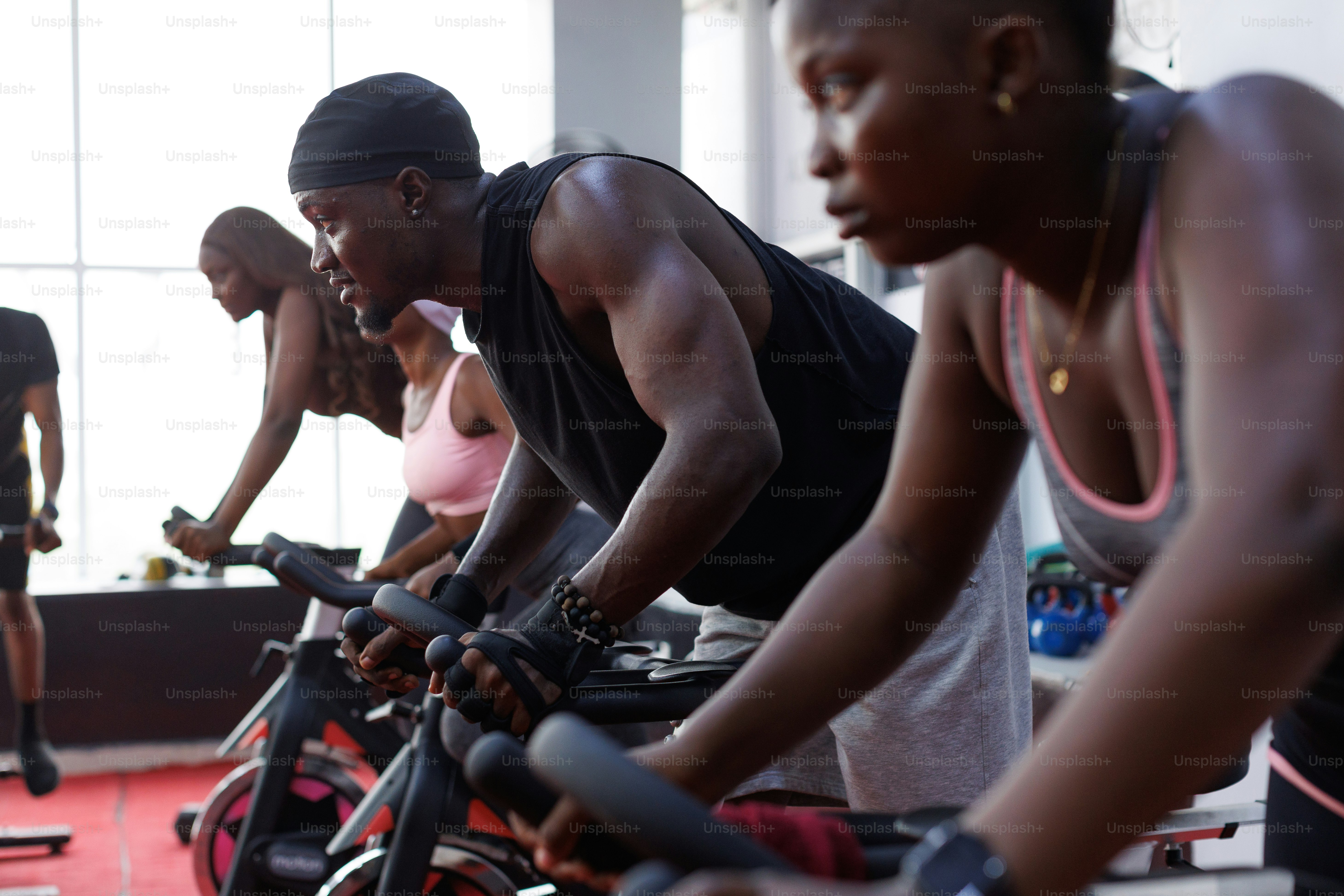 A group of people riding bikes in a gym photo – Fitness classes Image ...