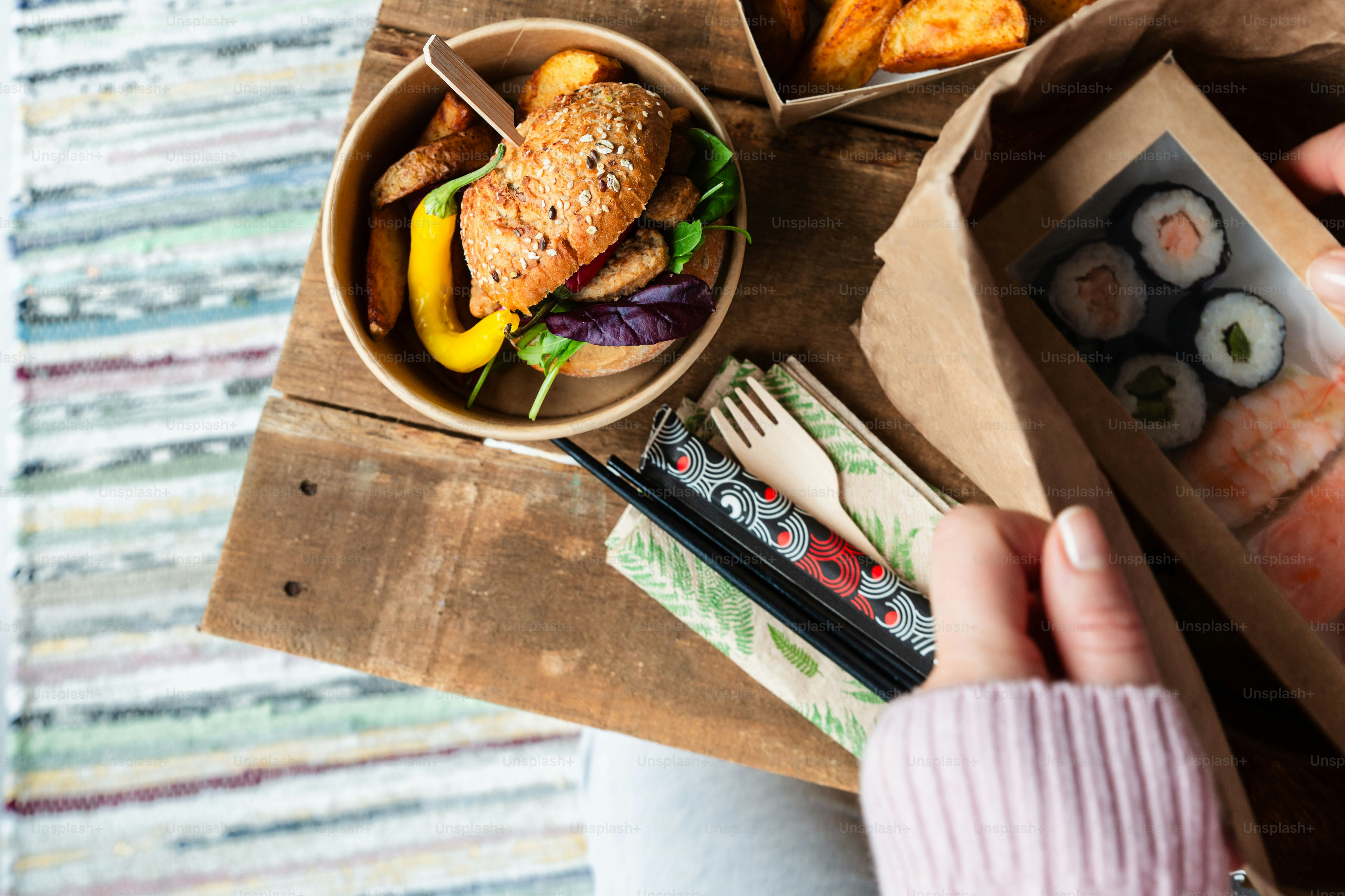 A person holding a remote control near a bowl of food photo – Burger ...