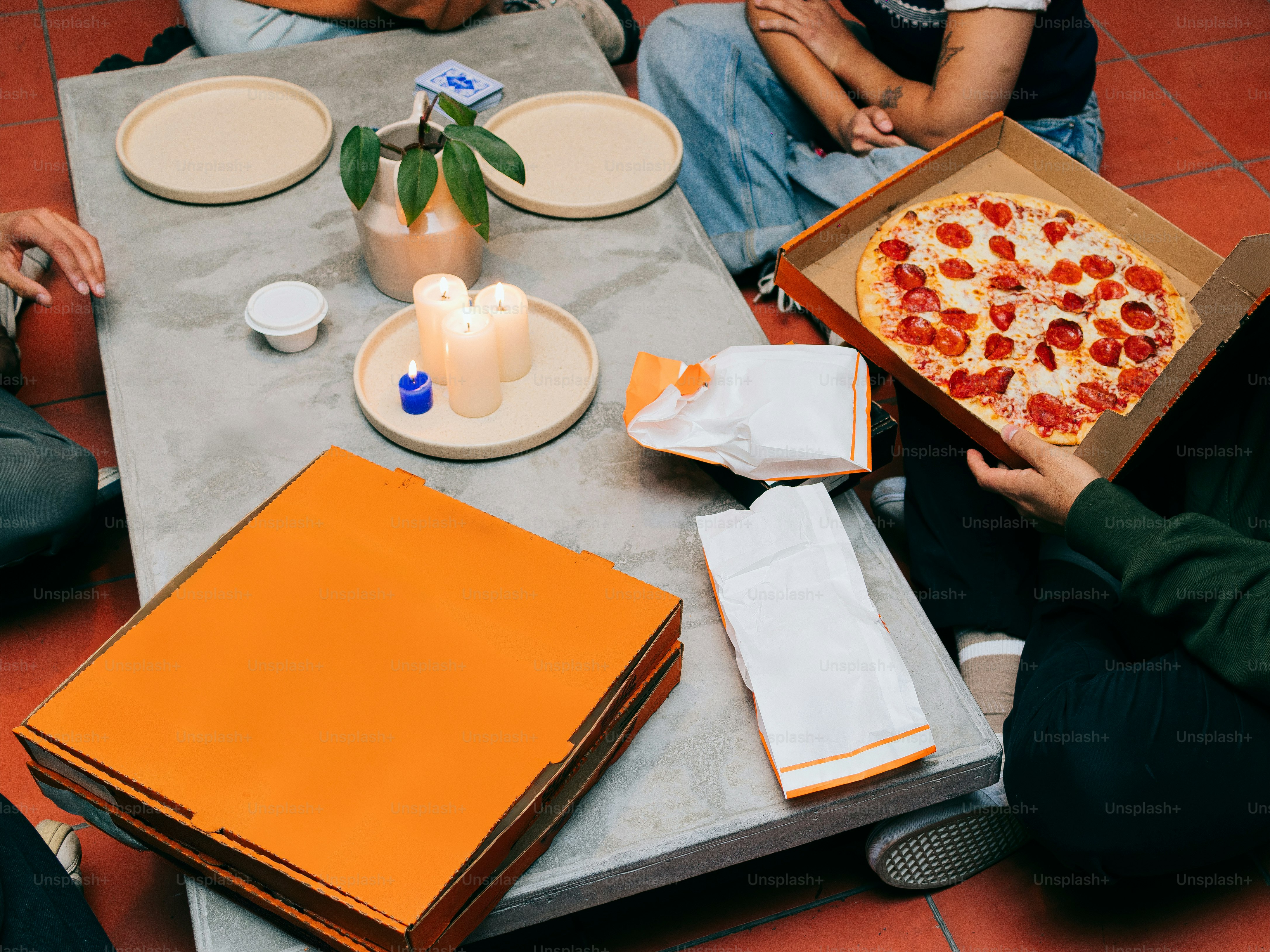A group of people sitting around a table eating pizza photo – Pizza ...