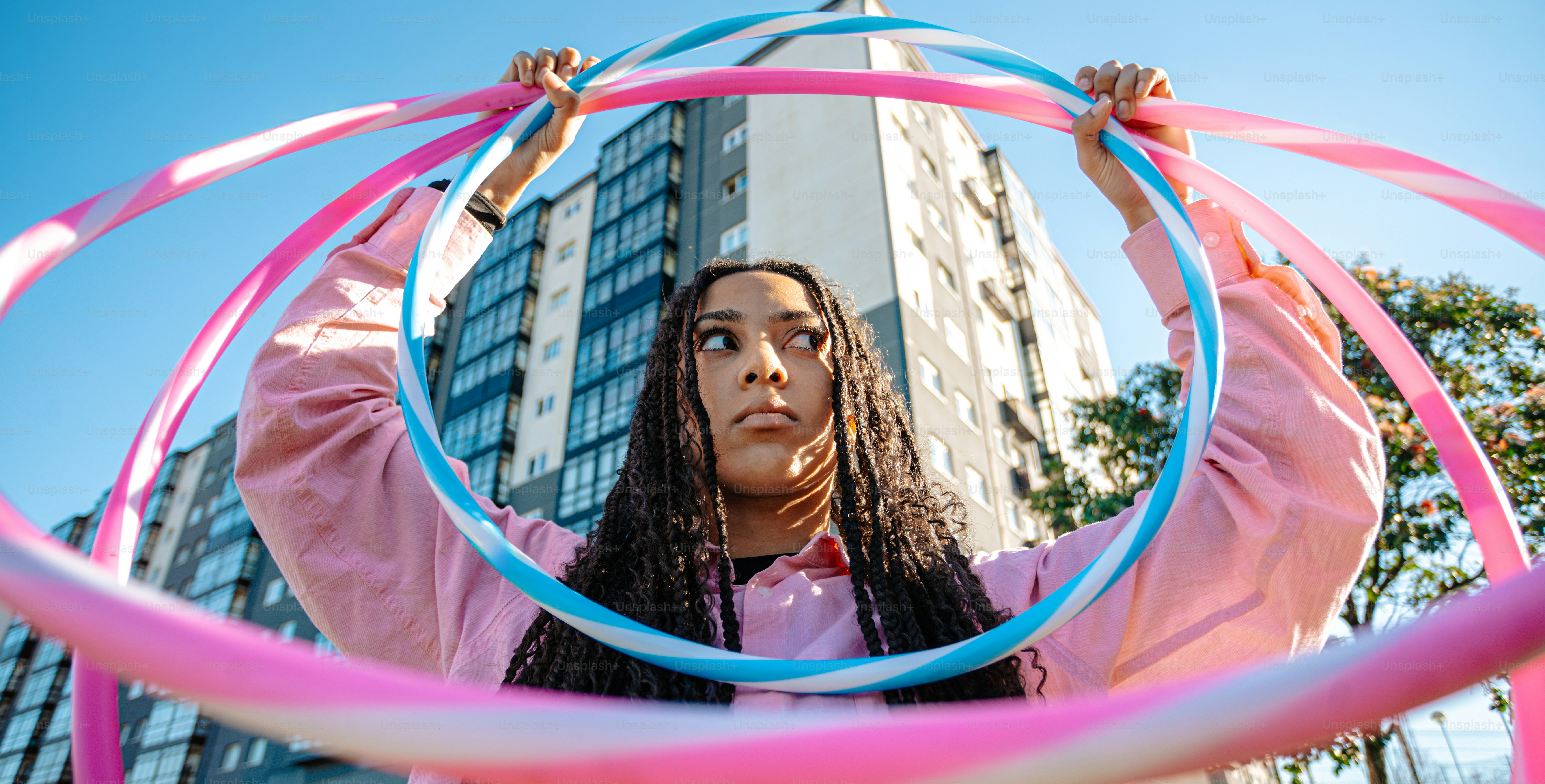 A woman holding a hula hoop in front of her face photo – Distorted view ...