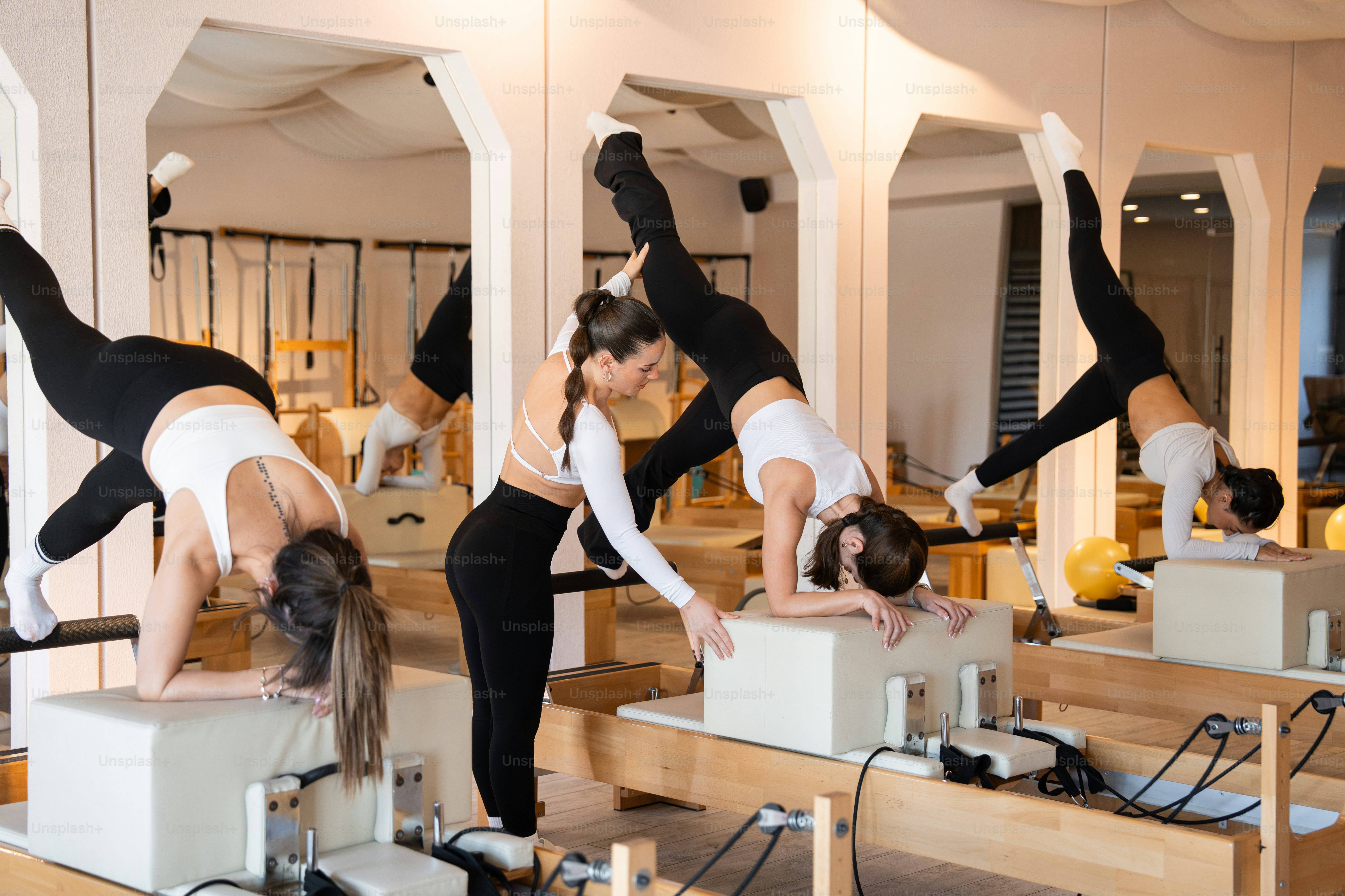 A group of people doing acrobatic exercises in a gym photo – Fitness ...