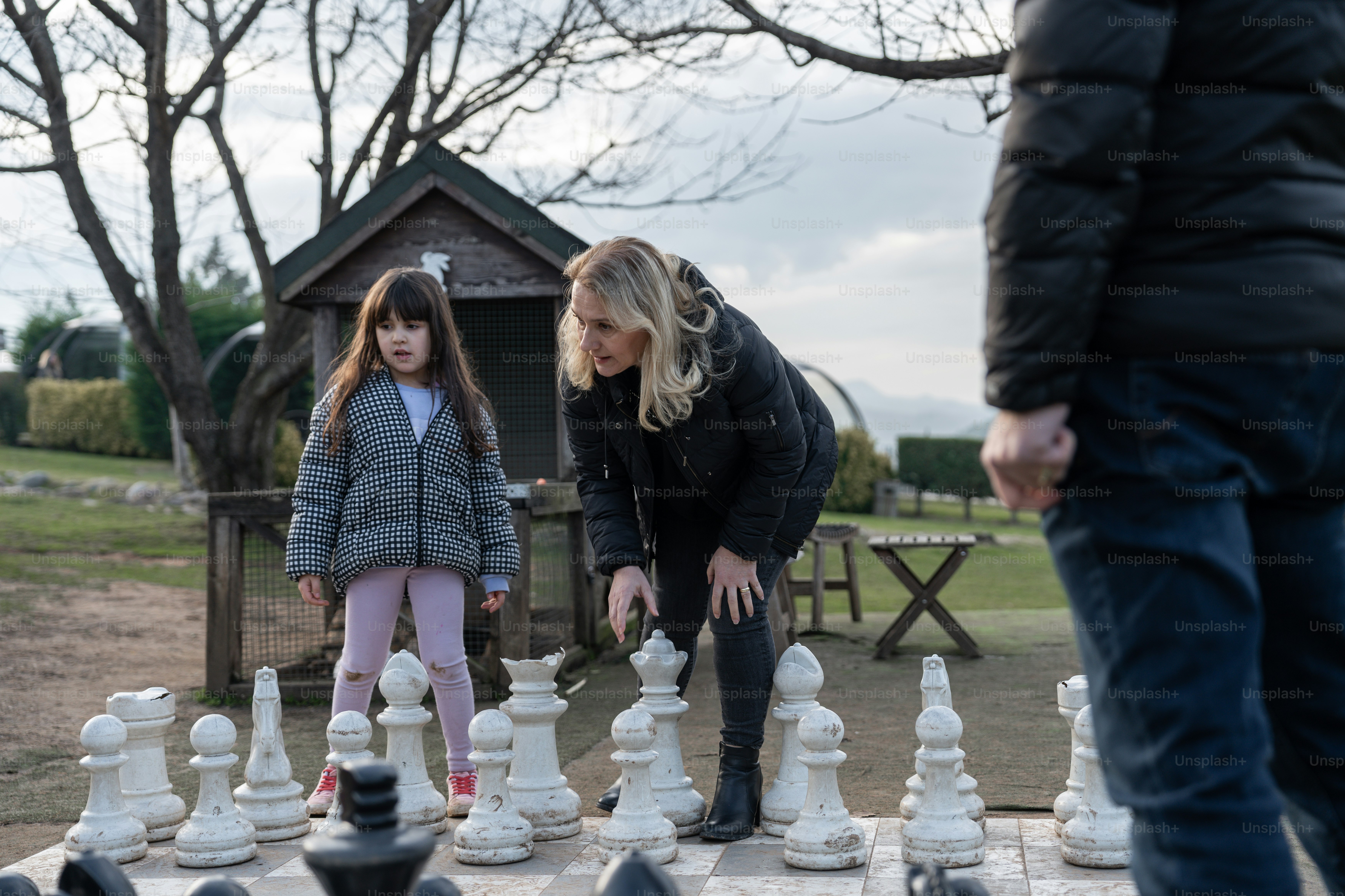 A group of people playing a game of chess photo – Playing chess Image ...