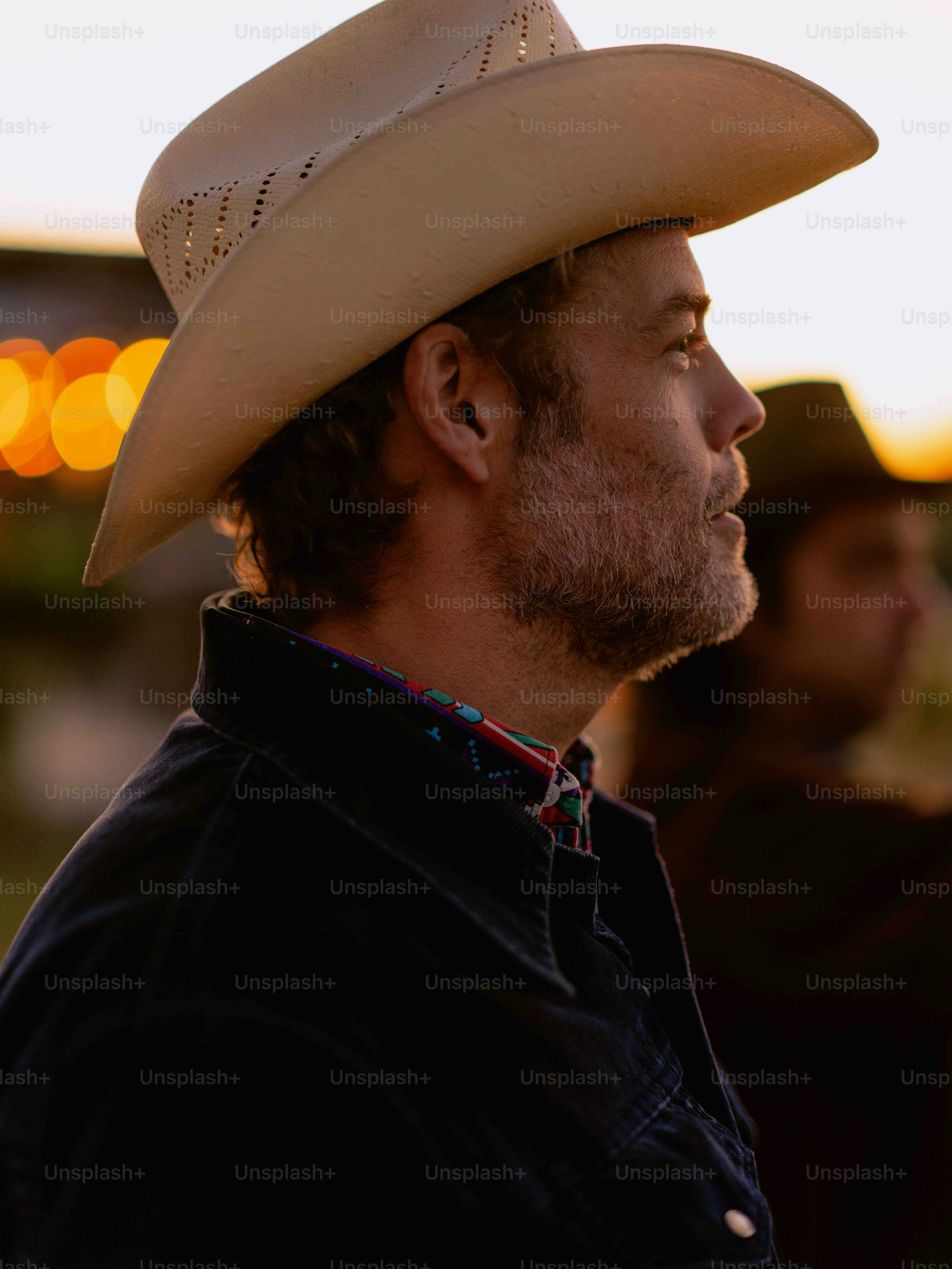 A man in a cowboy hat looking off into the distance photo – Portrait ...
