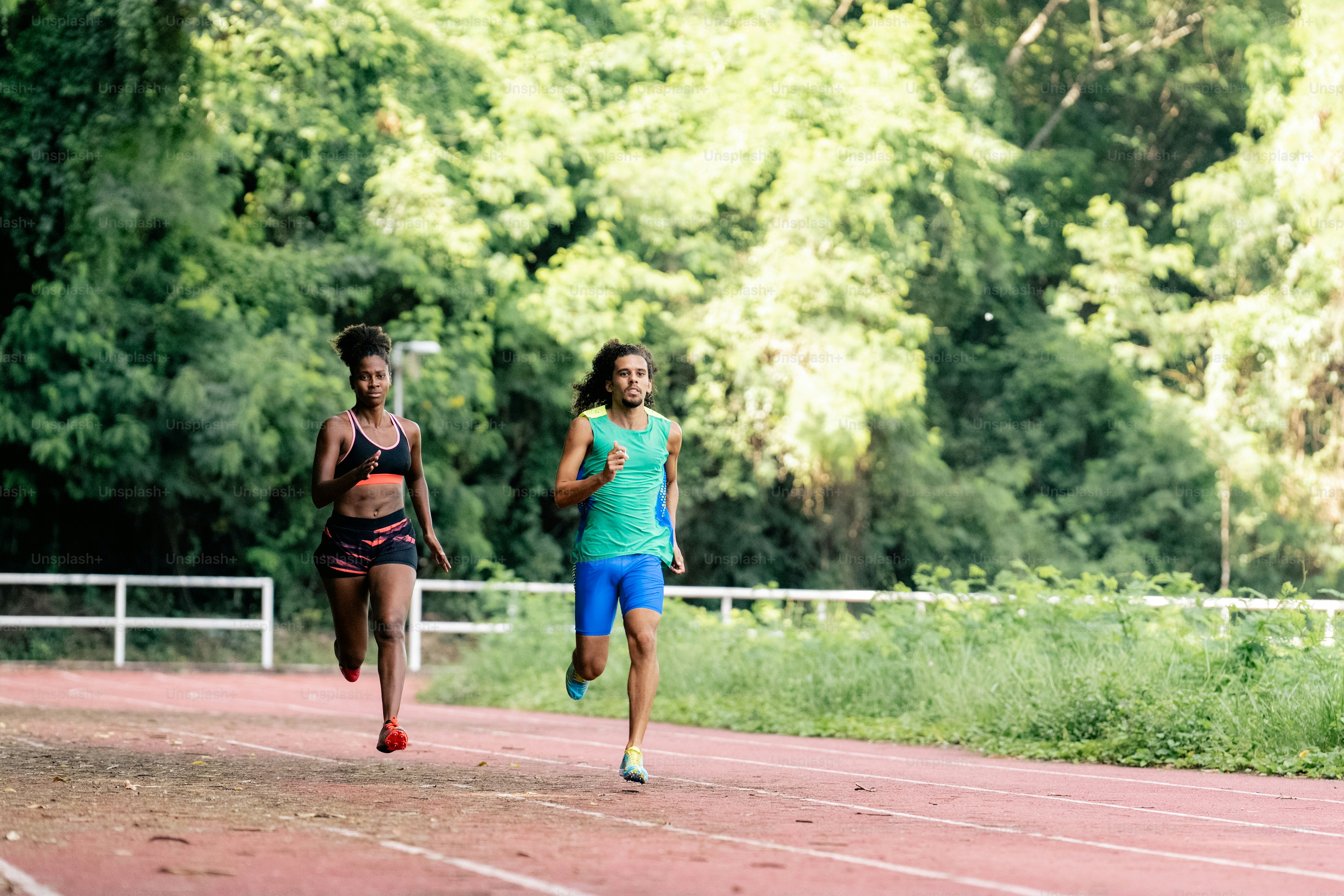 A couple of women running across a dirt road photo – Running Image on ...