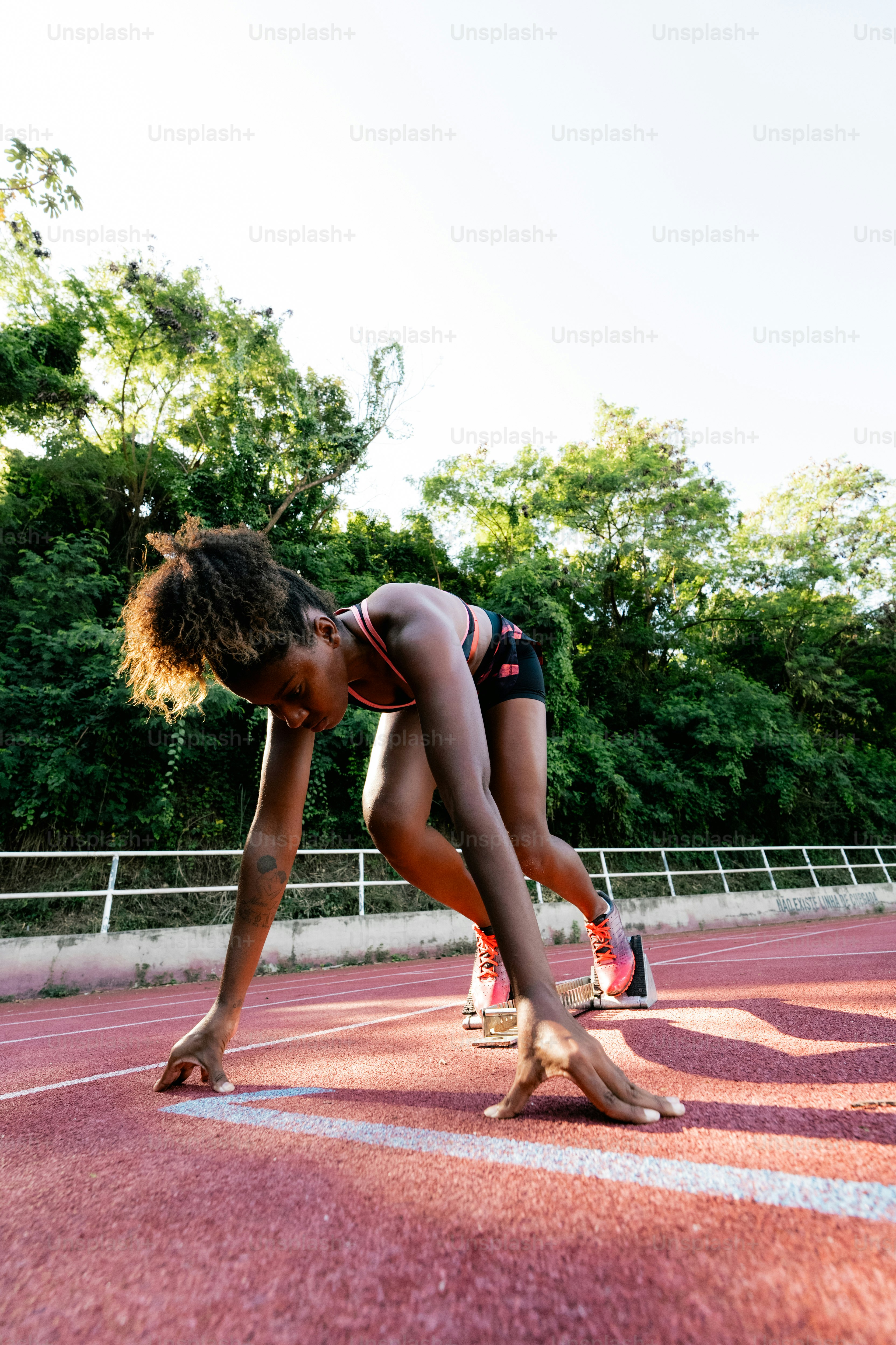 A woman is bending over on a track photo – Running Image on Unsplash