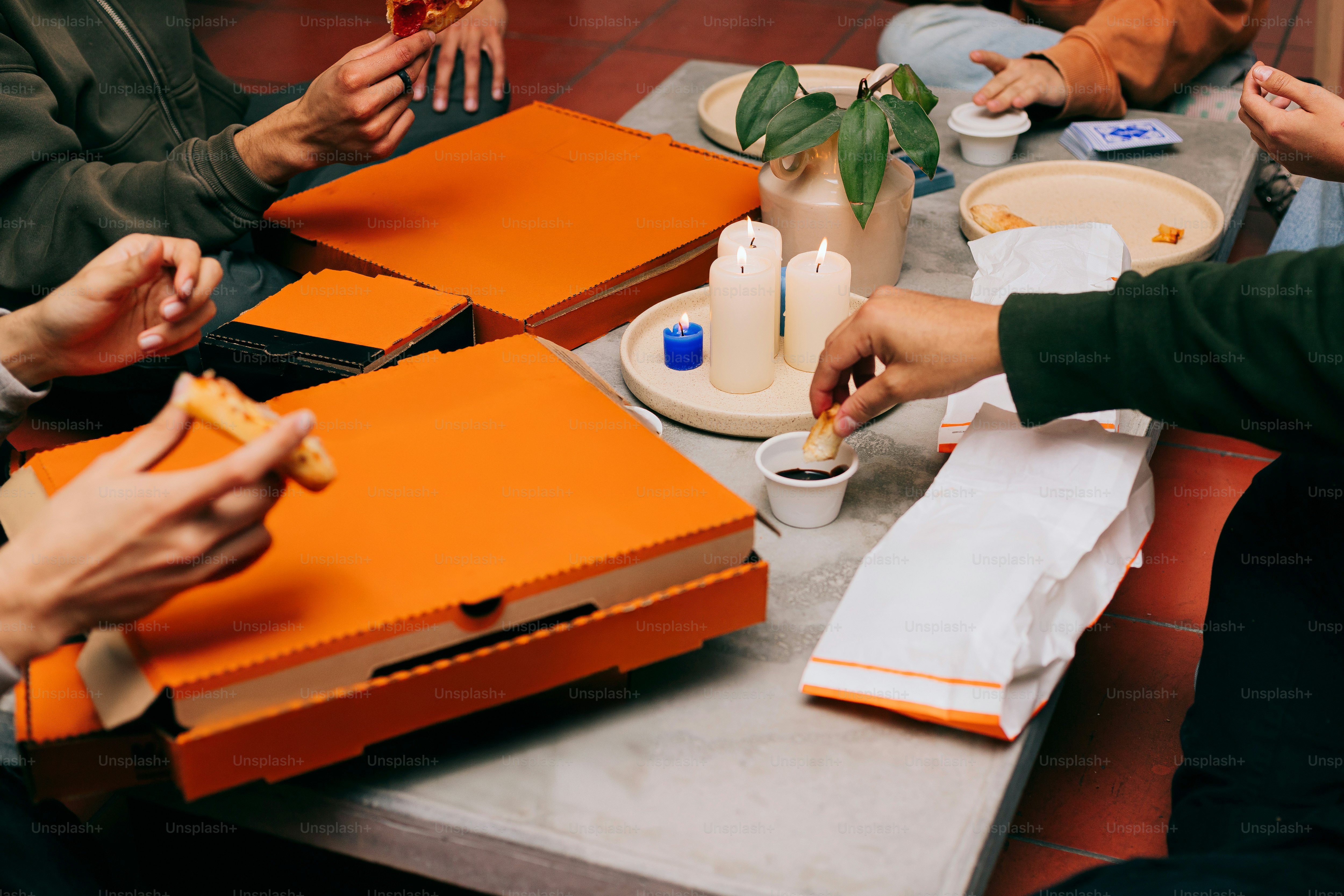 A group of people sitting around a table photo – Takeout food Image on ...