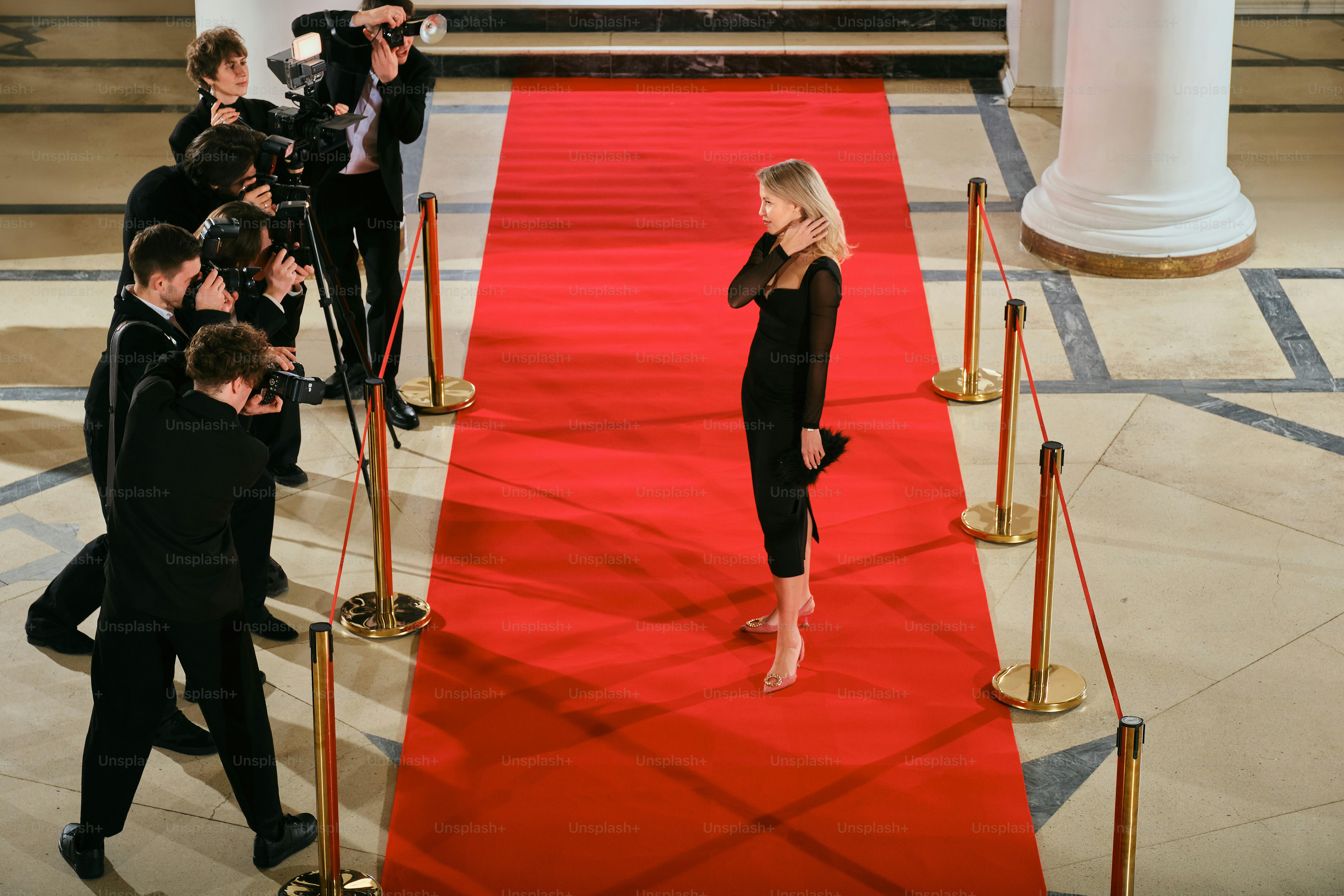 A woman in a black dress walking down a red carpet photo – Celebration ...