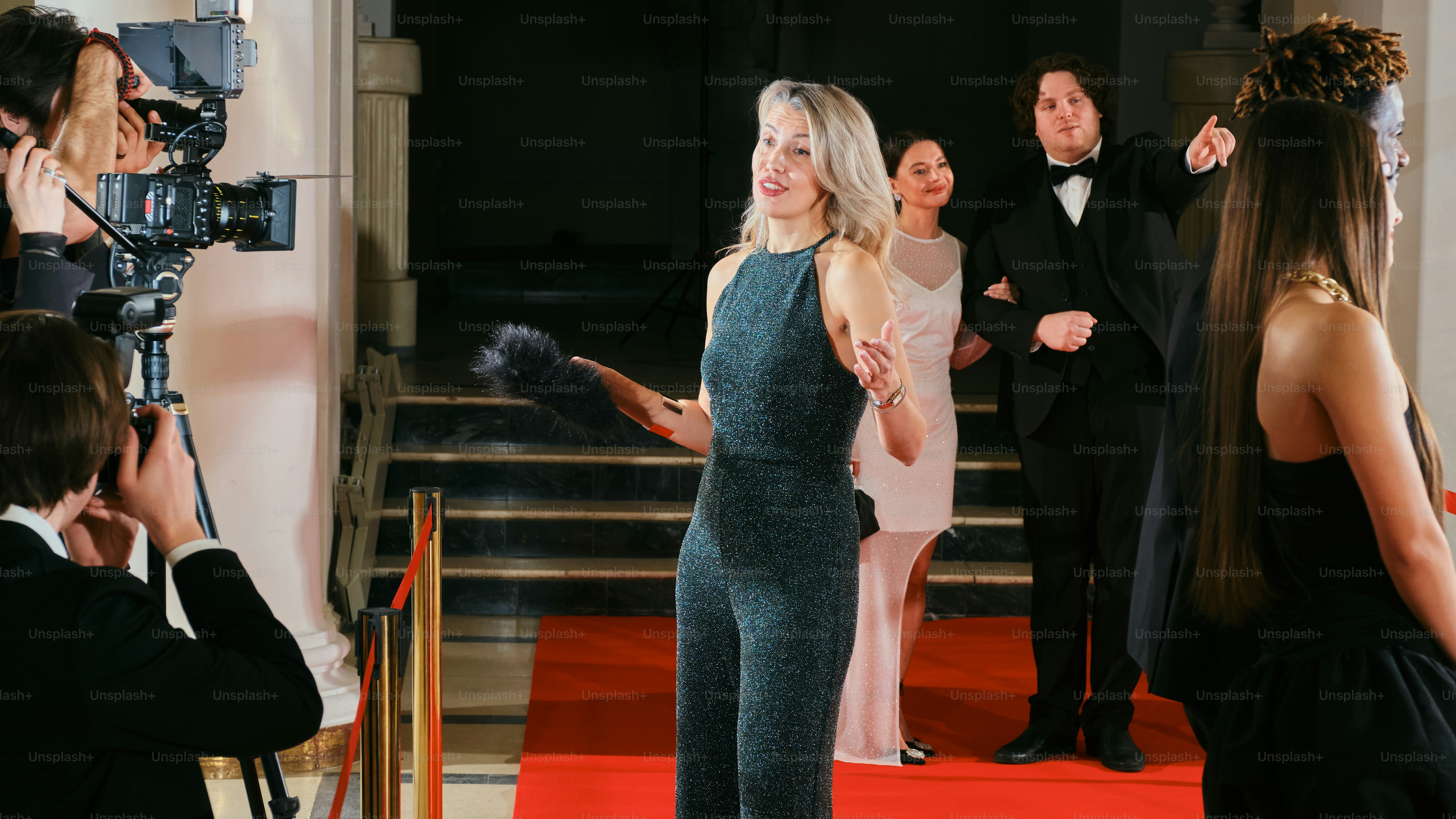A group of people standing around a red carpet photo – Celebration ...
