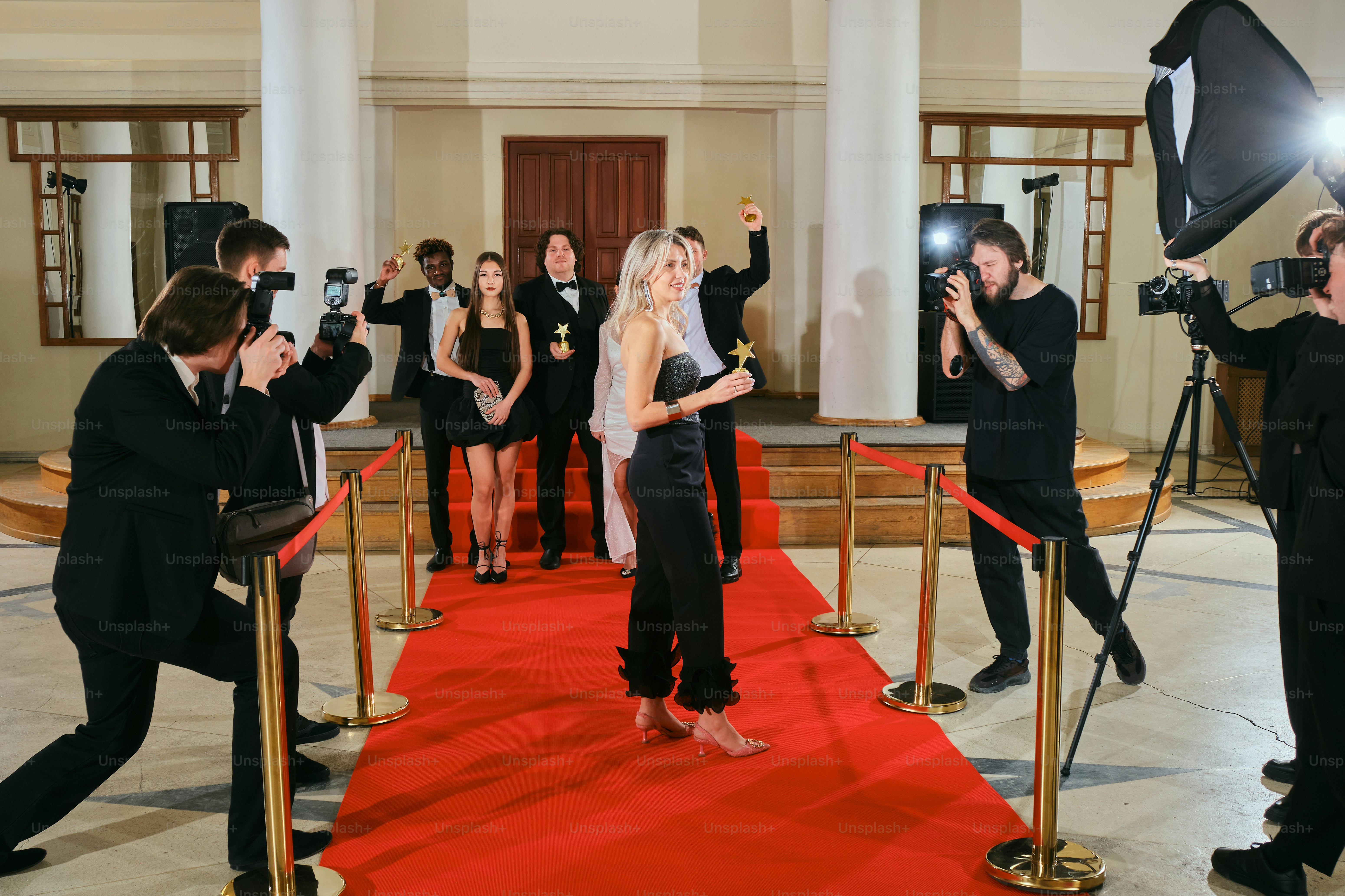 A group of people standing around a red carpet photo – Celebration ...