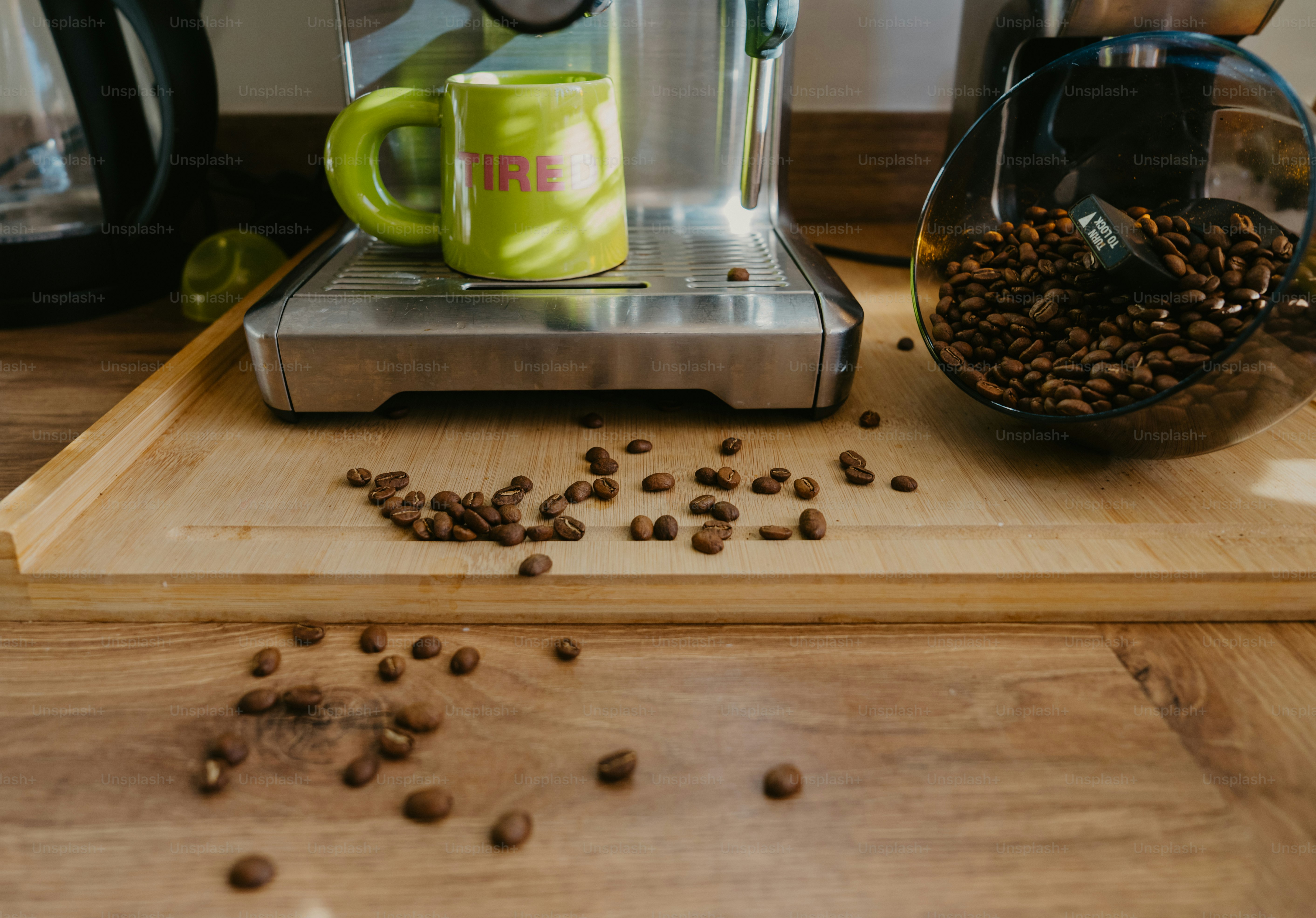 A coffee maker with coffee beans on a cutting board photo – Playful ...