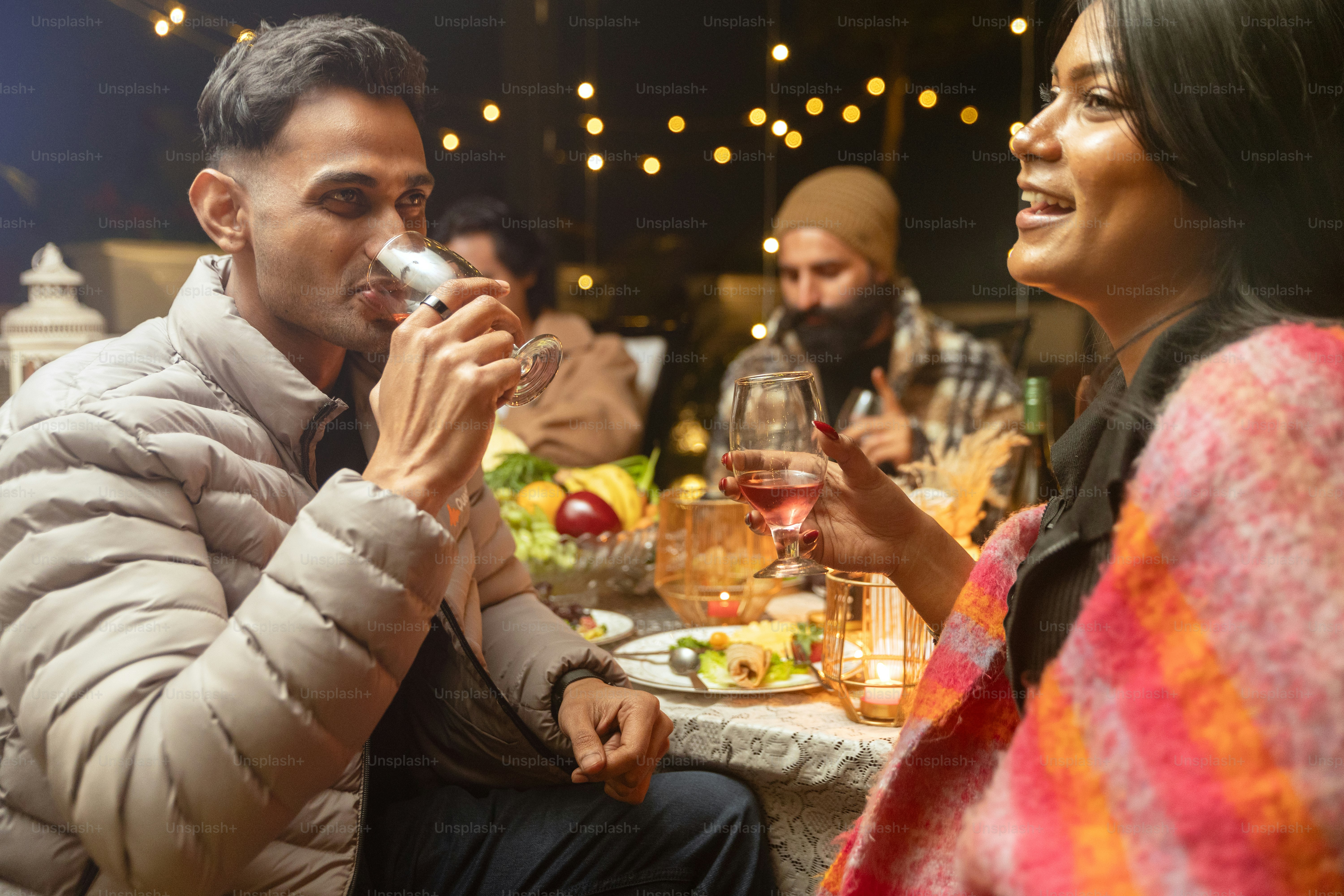 A group of people sitting around a dinner table photo – Eating Image on ...