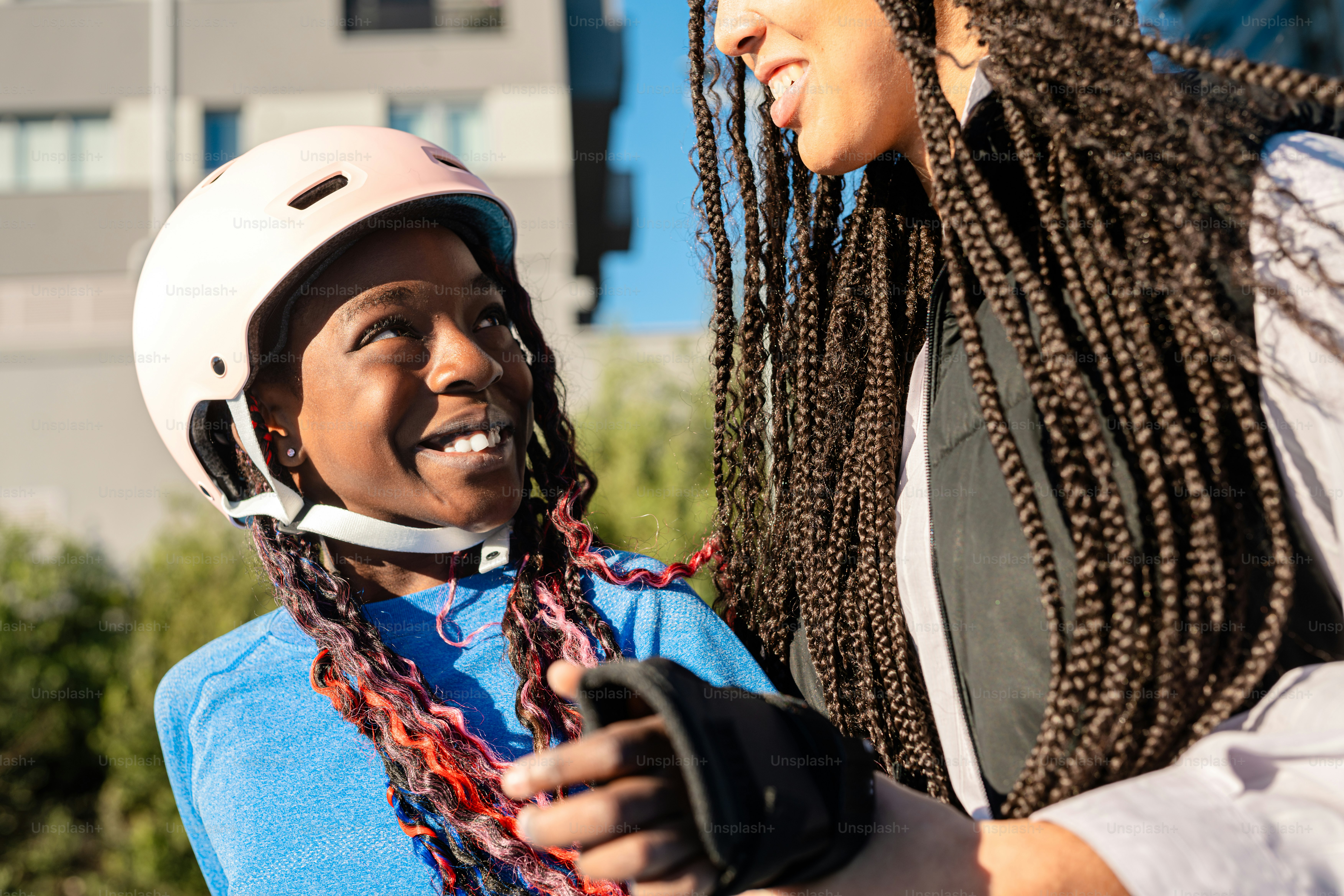 A woman with a helmet talking to a man with dreadlocks photo – Helmet ...