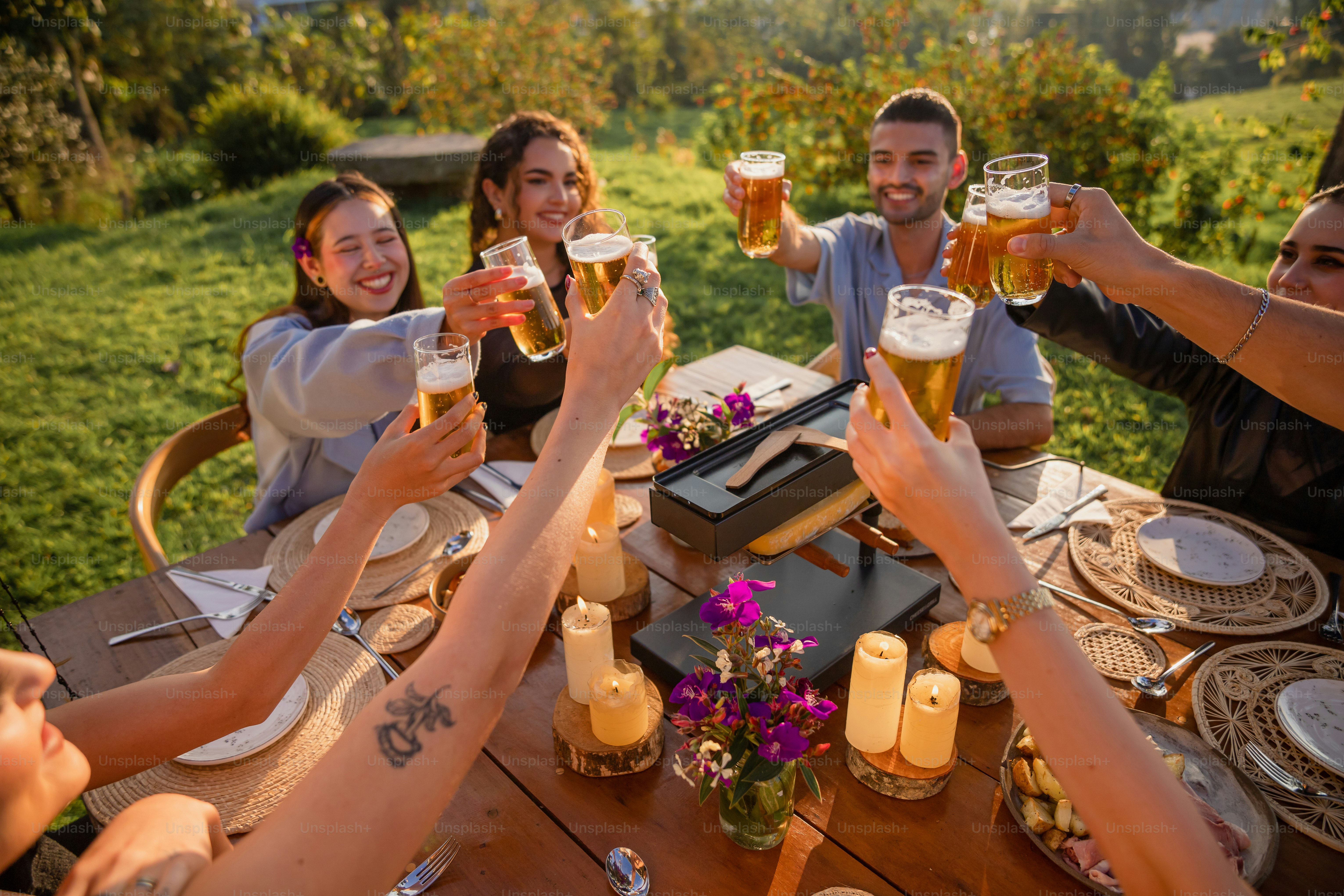 A group of people sitting around a table drinking beer photo – Food ...