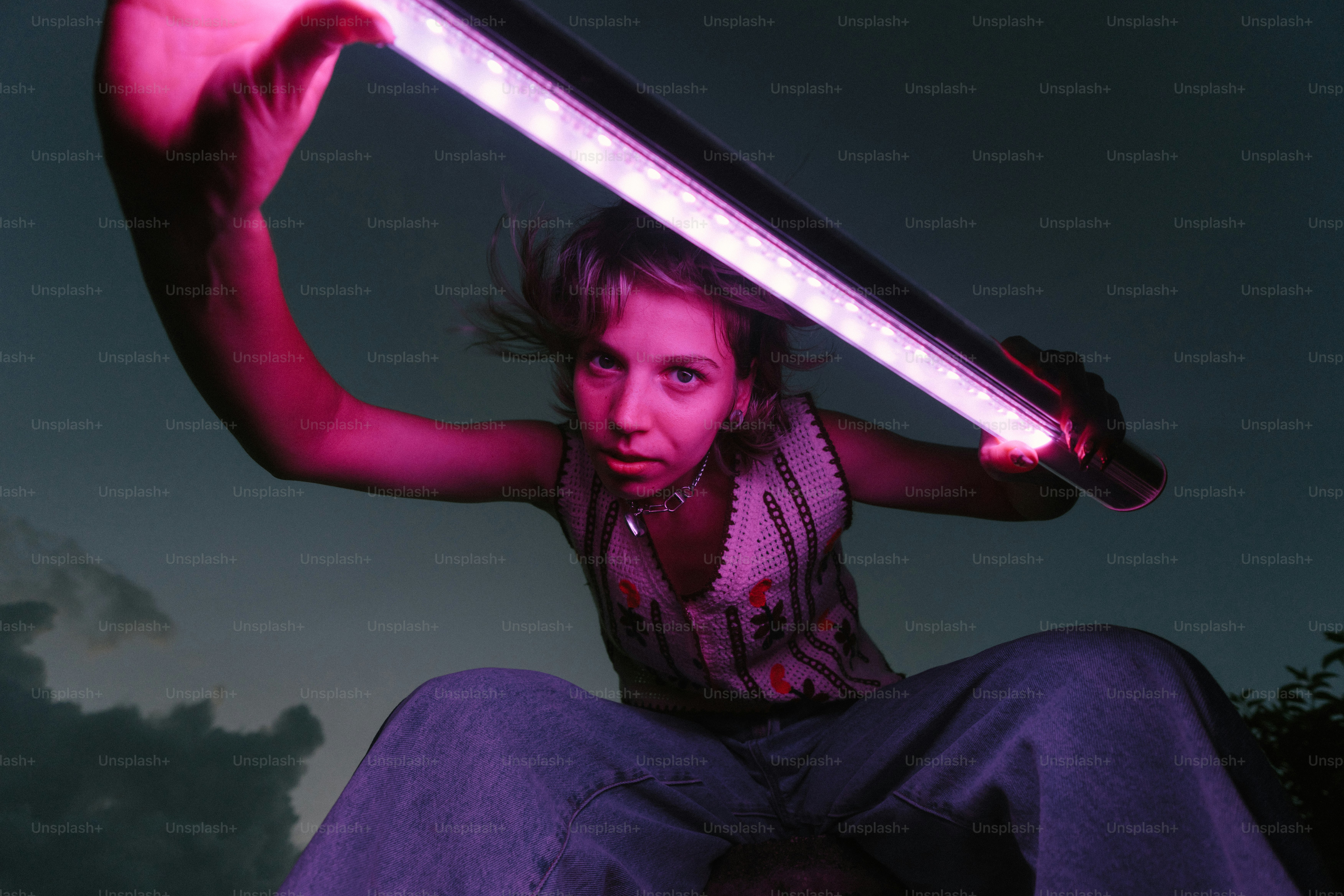 A woman holding a large sword over her head photo – Wide angle Image on ...