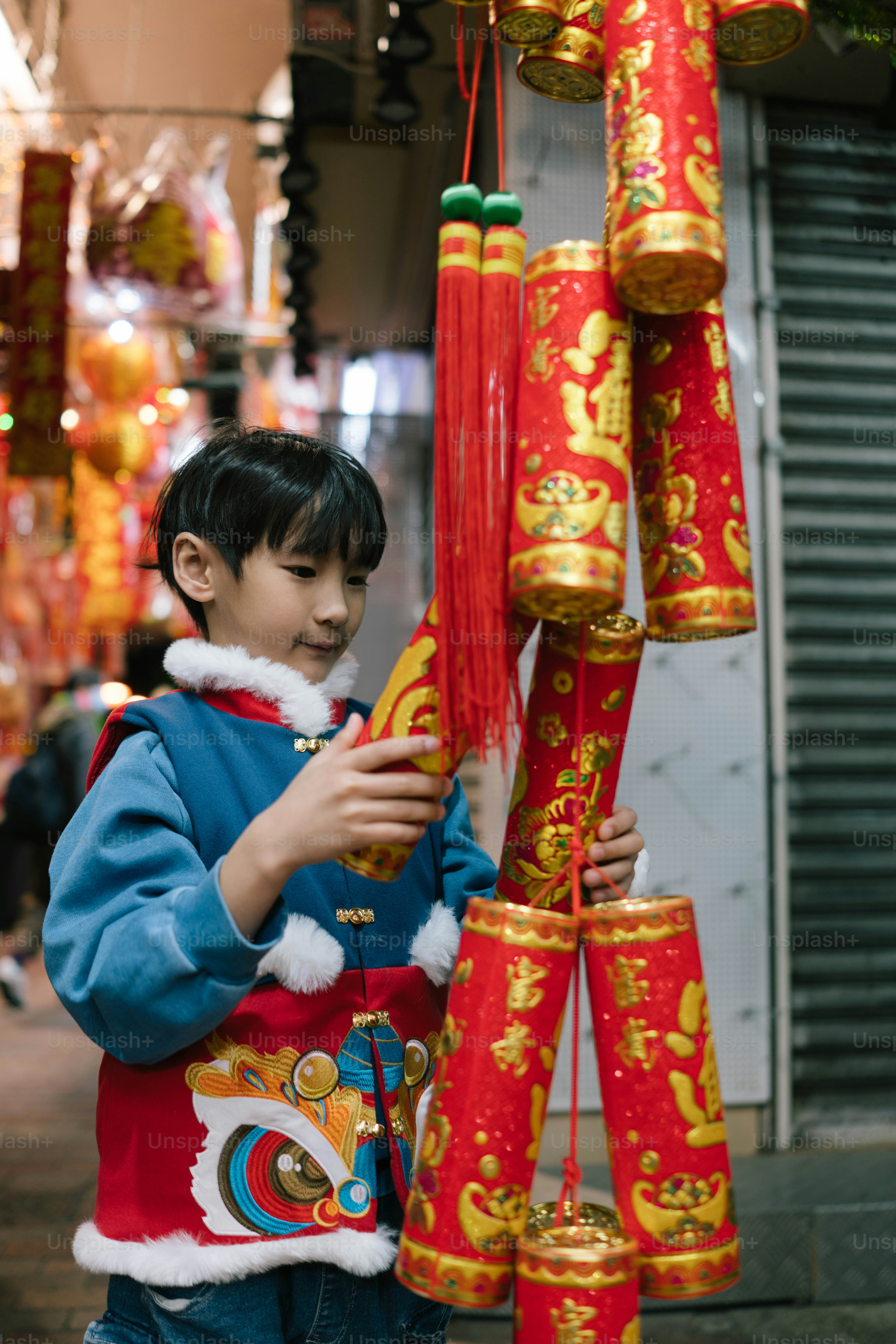 A young boy standing next to a red and gold pole photo – Boy Image on ...