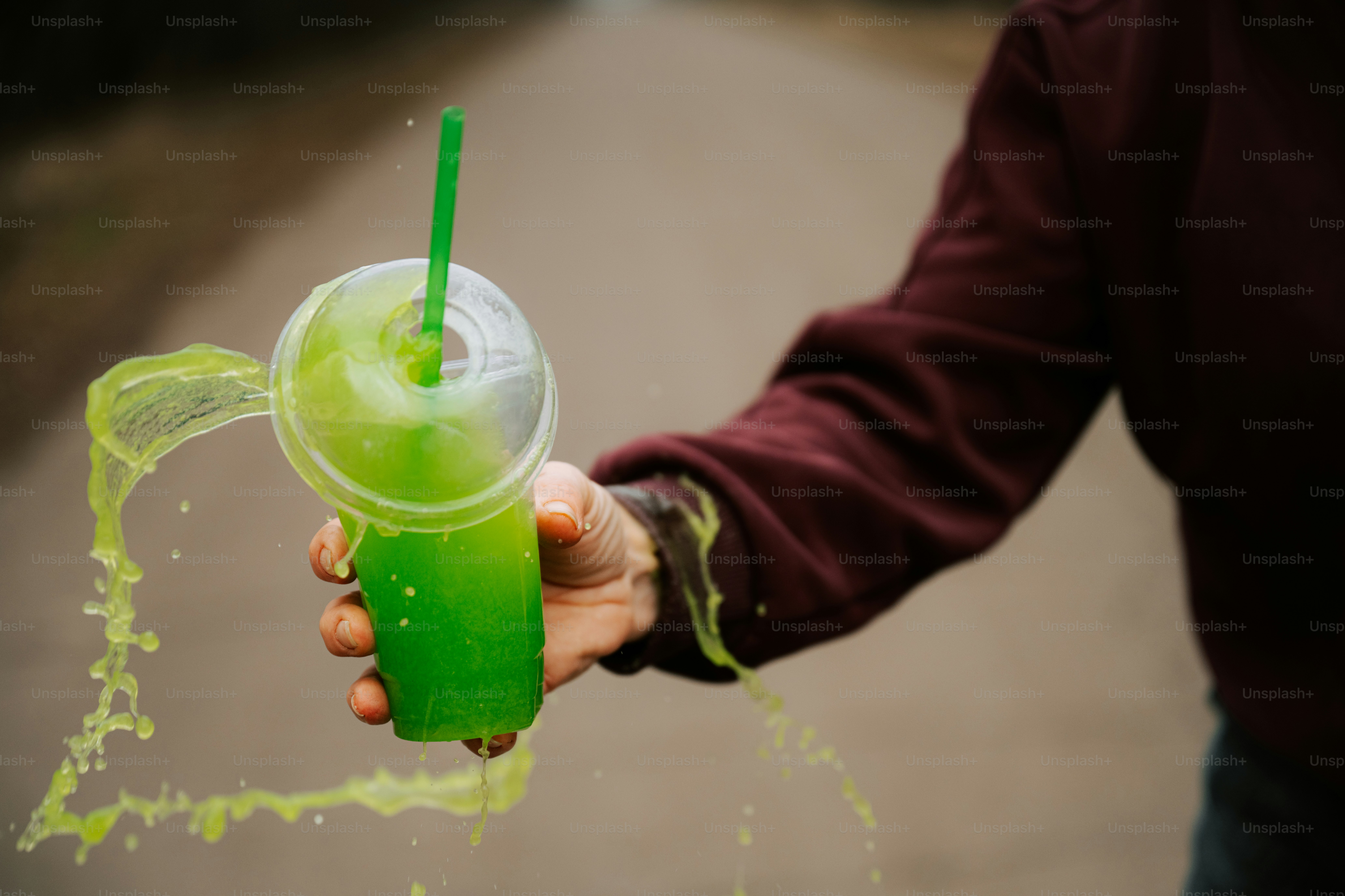 A person holding a green drink in their hand photo – Accident Image on ...