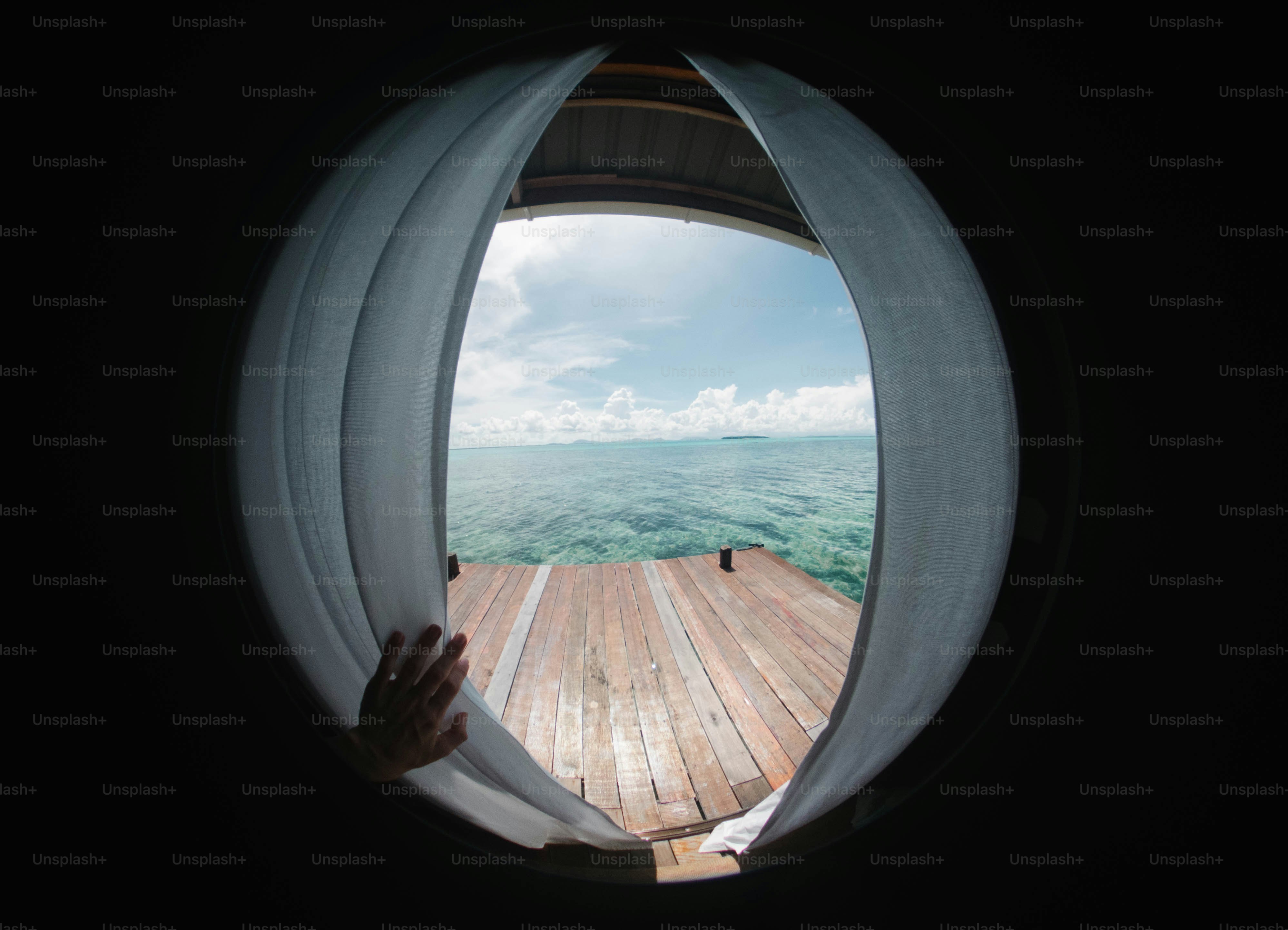 A person looking out of a window at the ocean photo – Water Image on ...