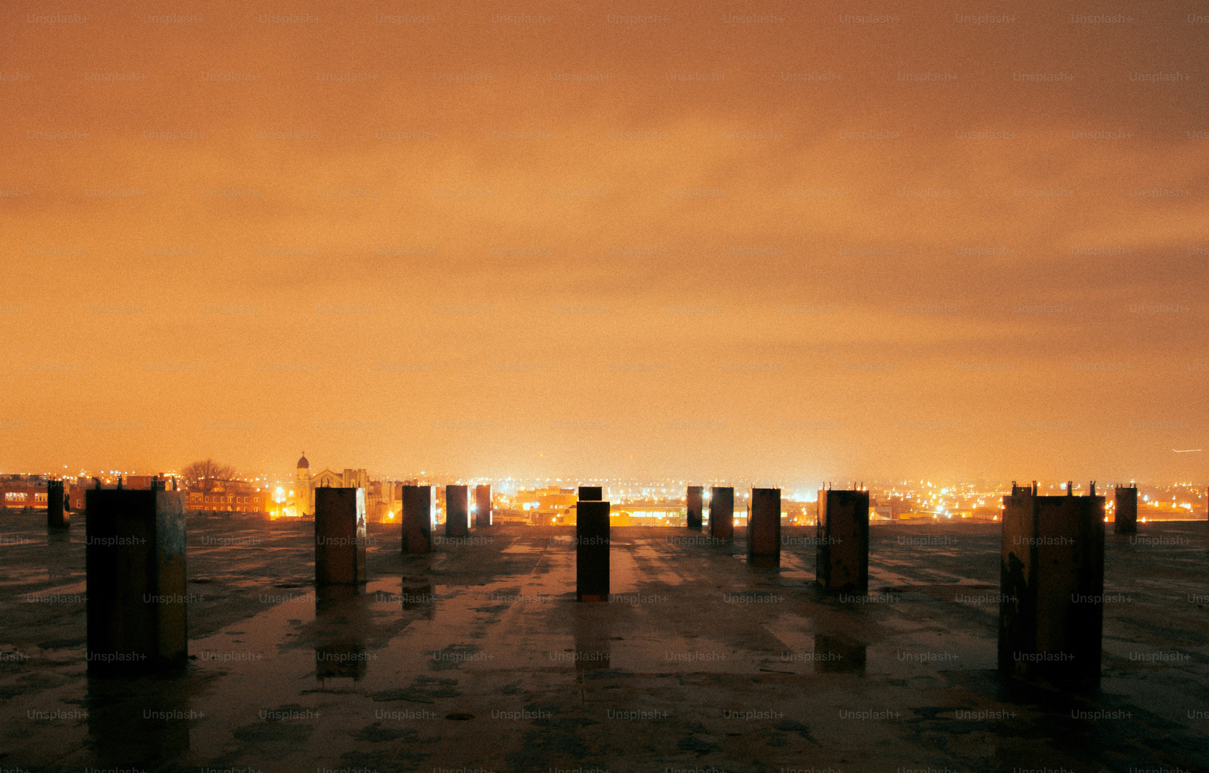 A group of poles sitting in the middle of a body of water photo – City ...