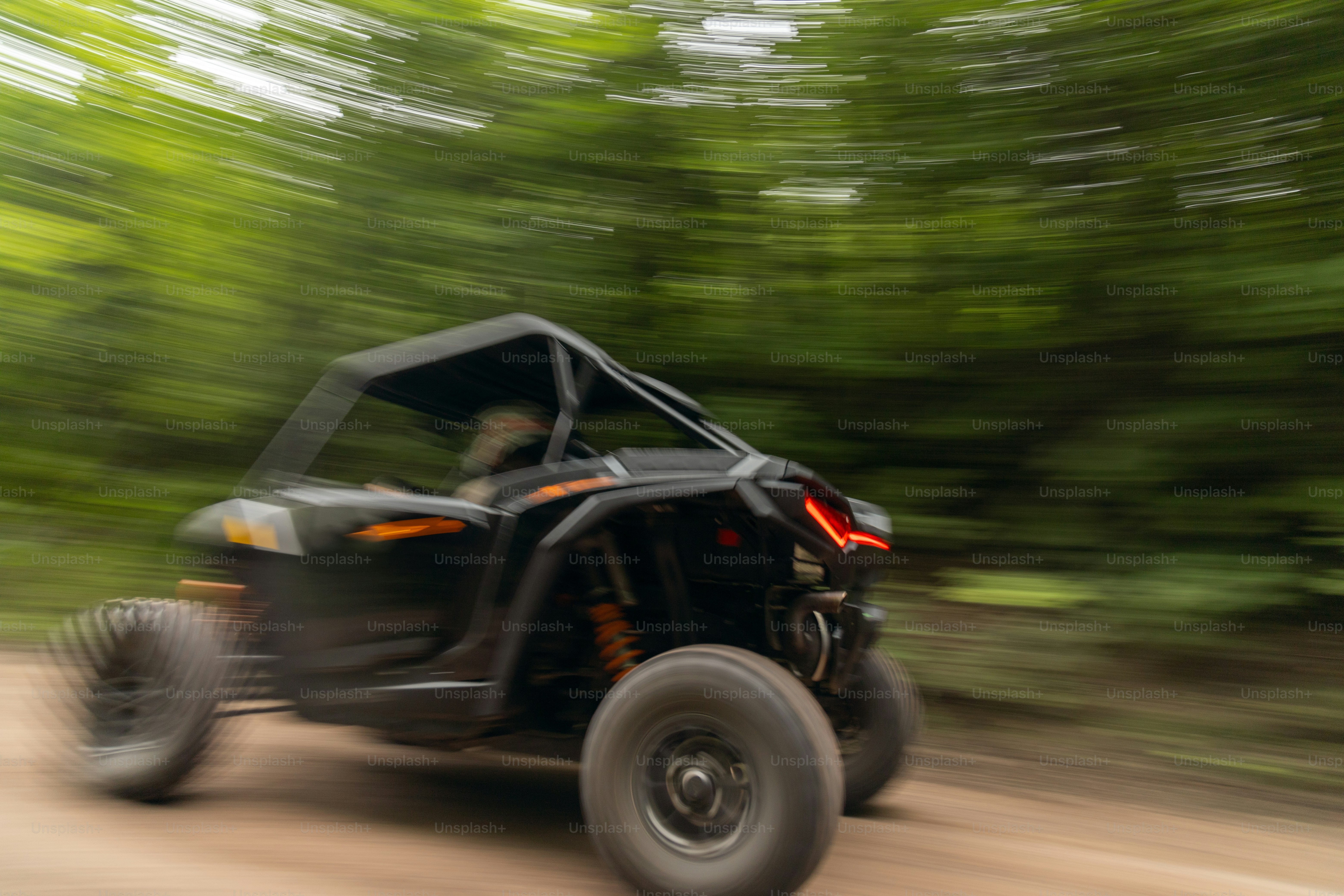 A person riding a four wheeler on a dirt road photo – Blur Image on ...