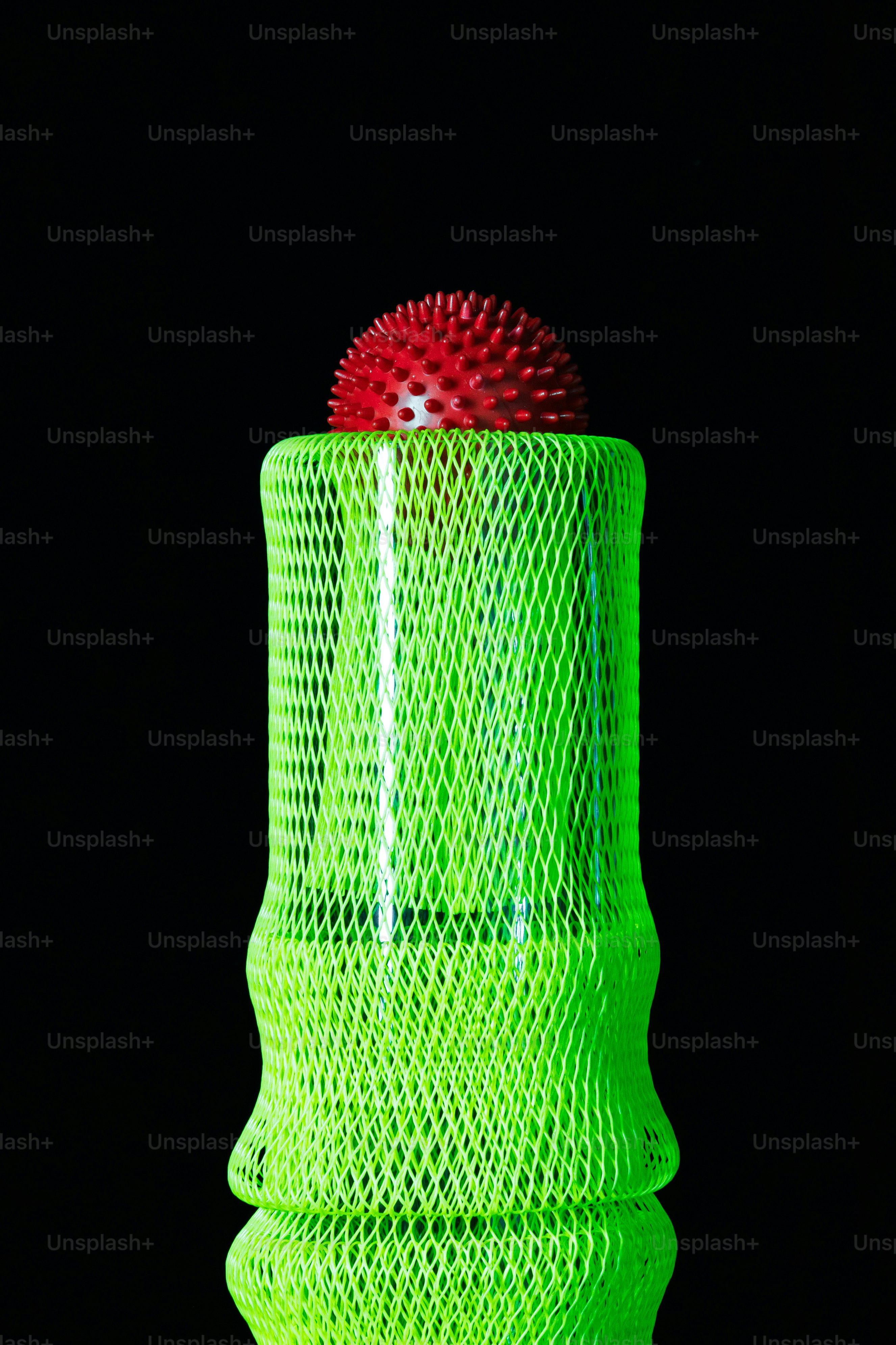 A green mesh object with a red ball in it photo – Abstract Image on ...