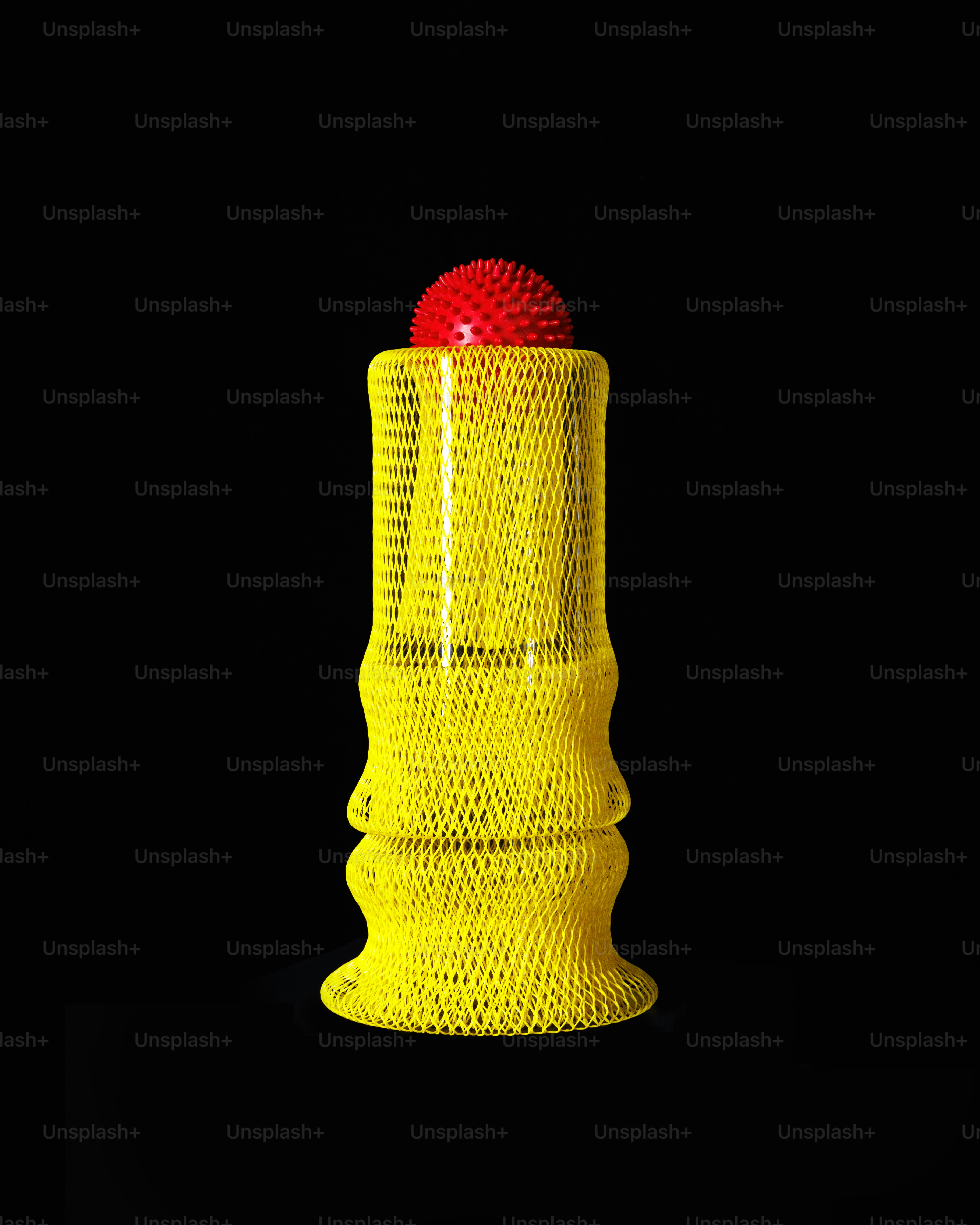A yellow object with a red ball on top of it photo – Wallpaper Image on ...