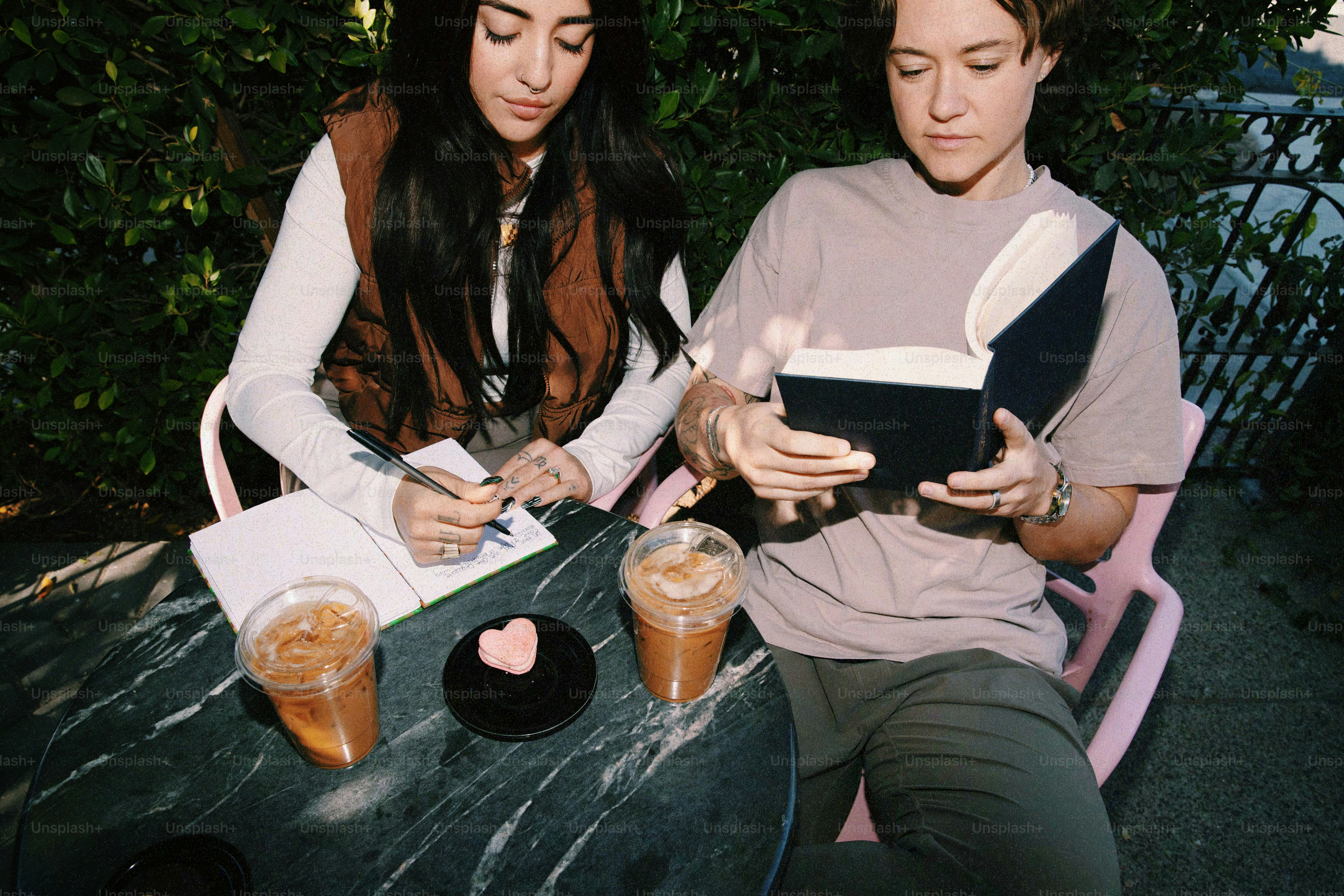 Two people are working and reading at an outdoor table. photo – Love ...