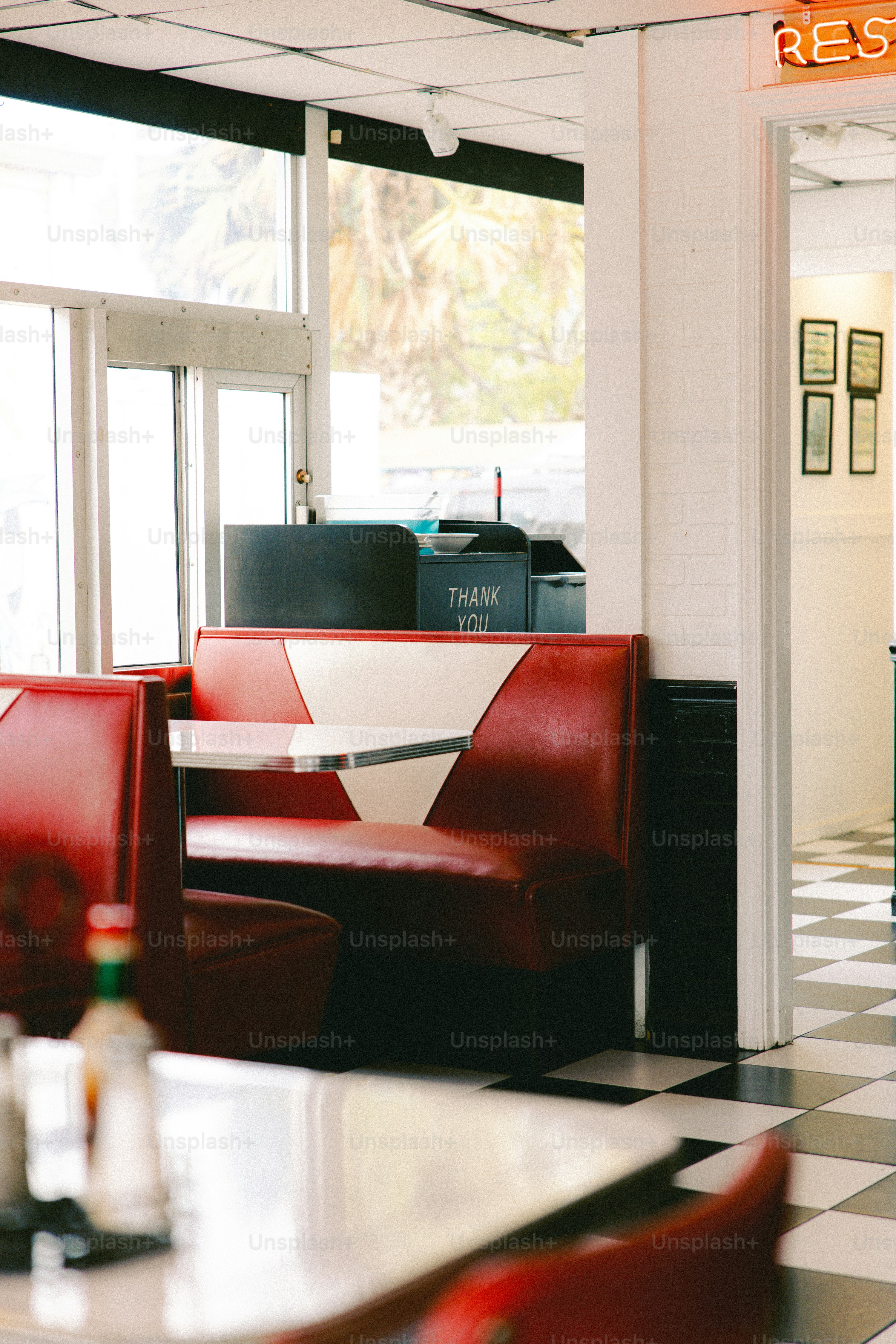A restaurant with a checkered floor and red booths photo – Cafe Image ...