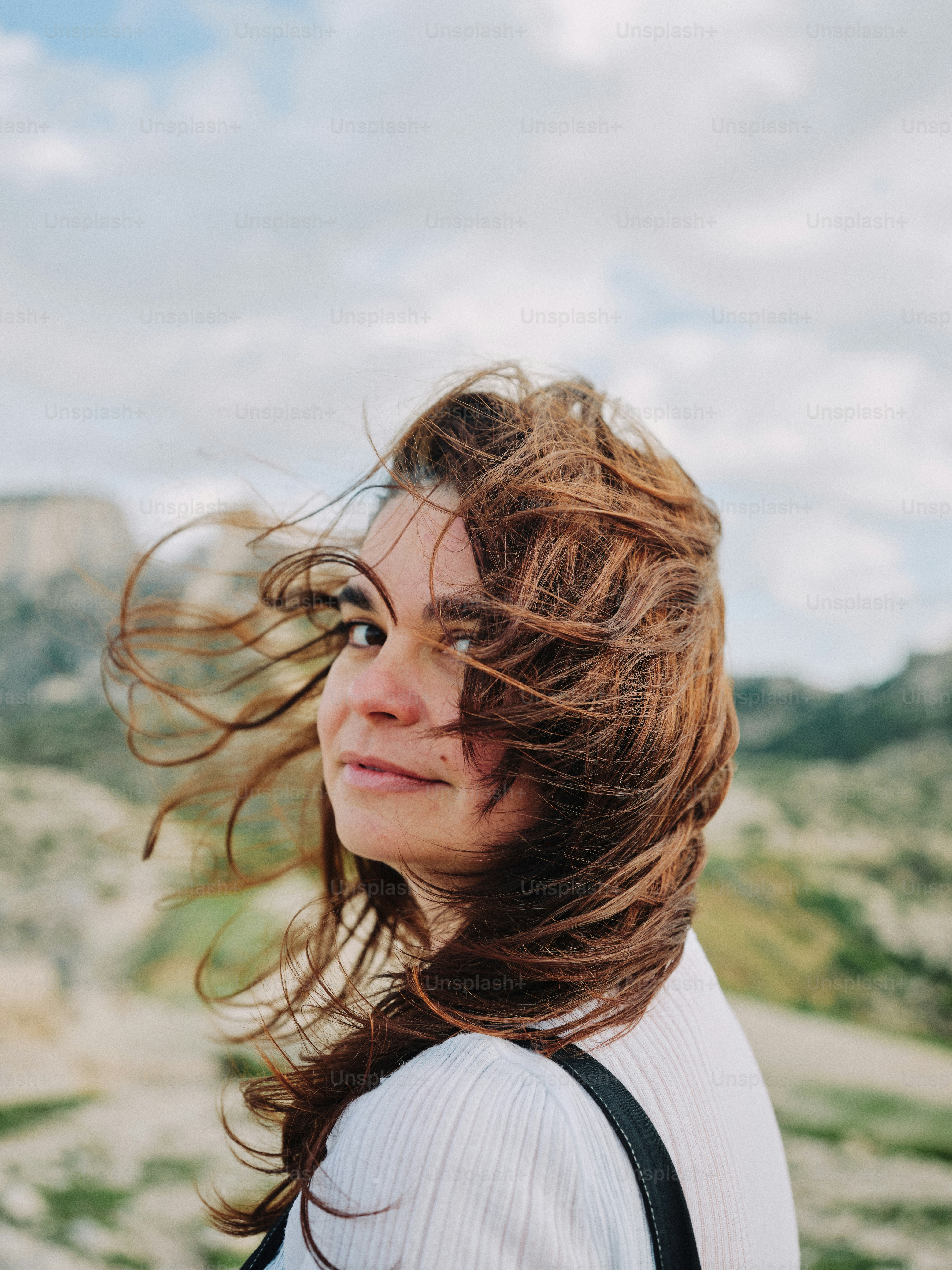 Woman with windblown hair looks at the camera. photo – Woman Image on ...