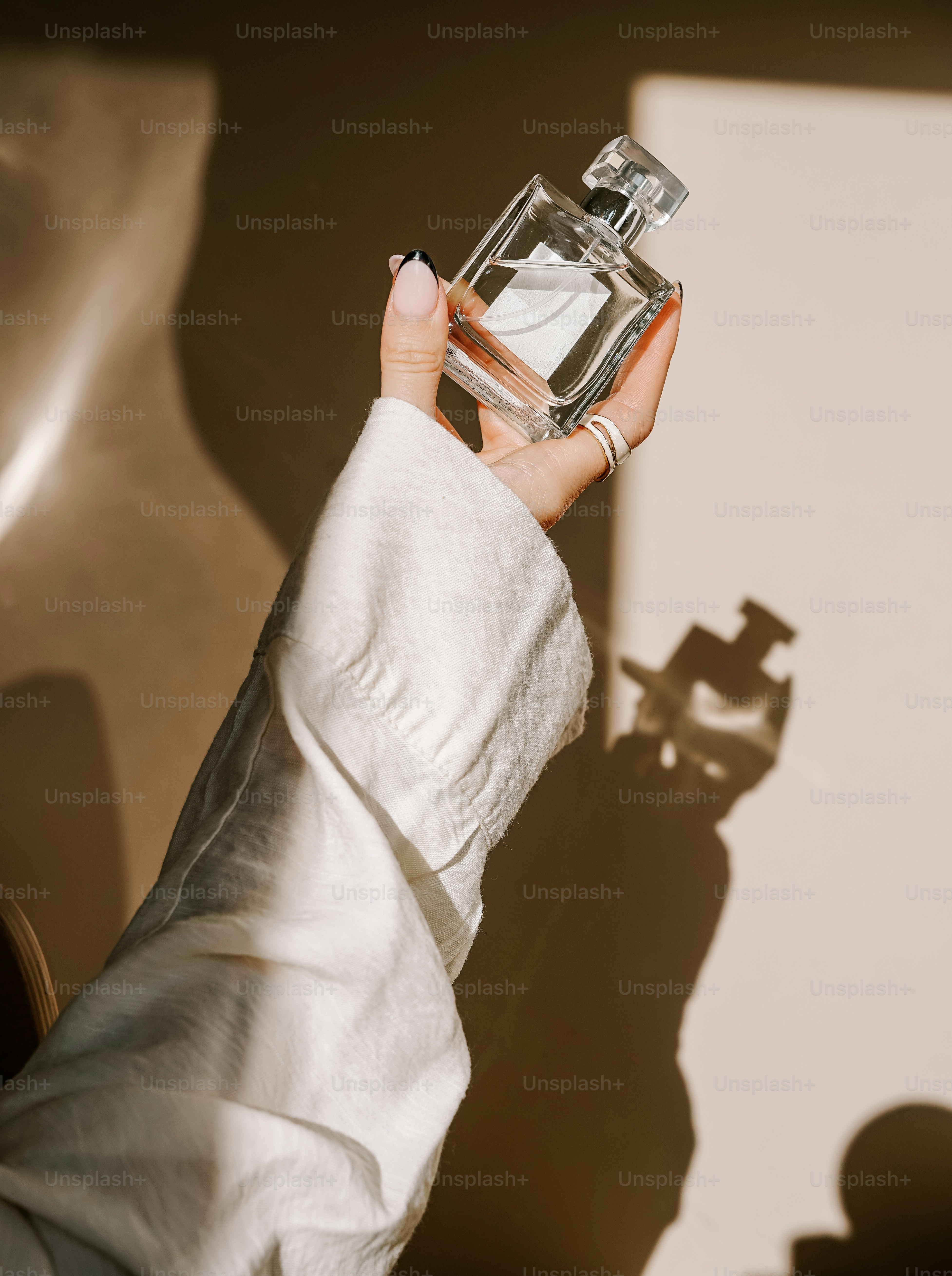 Una mujer con un frasco de perfume en la mano foto – Imagen de ...