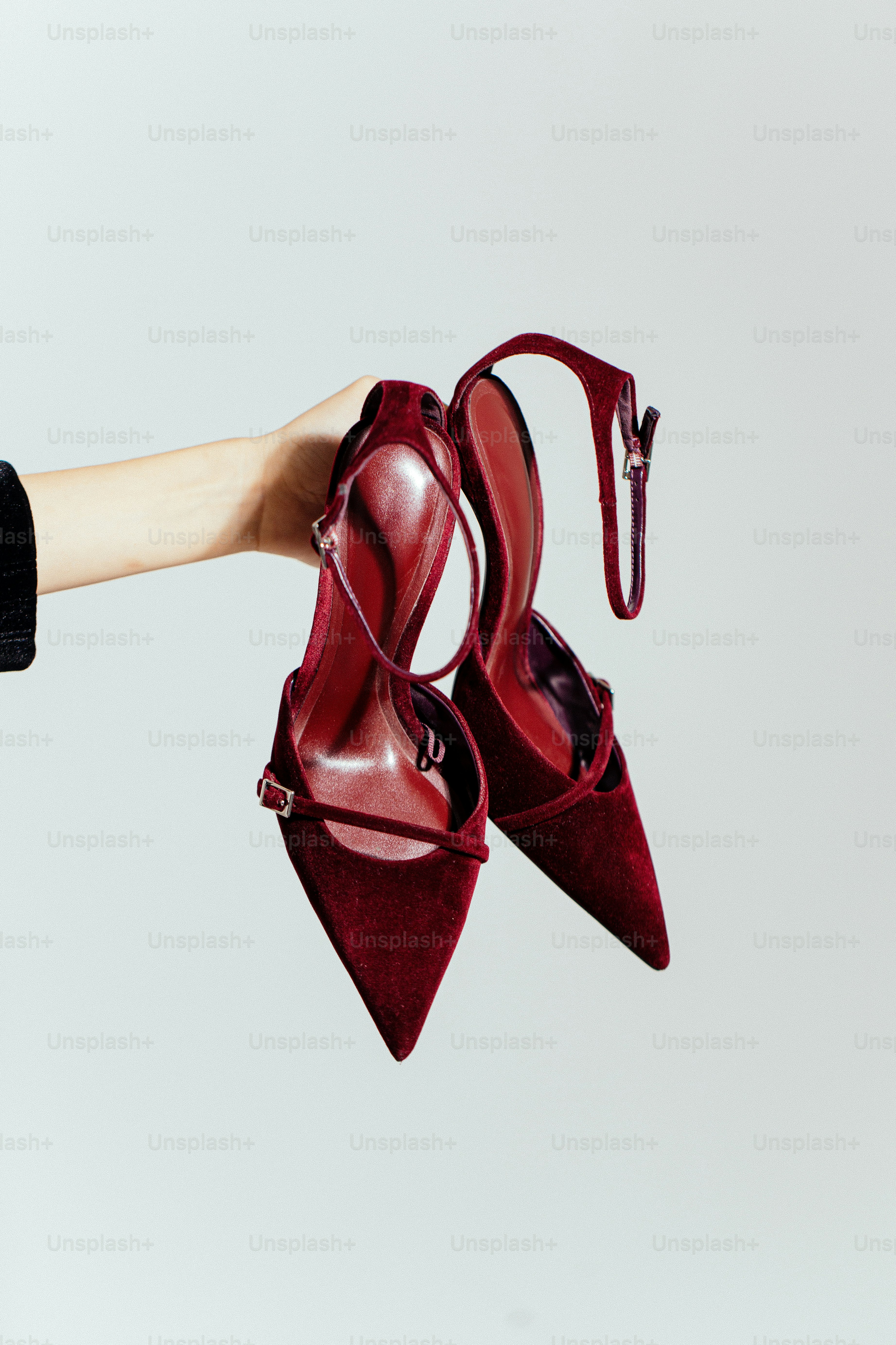 La main d’une femme tenant une paire de talons hauts rouges photo ...