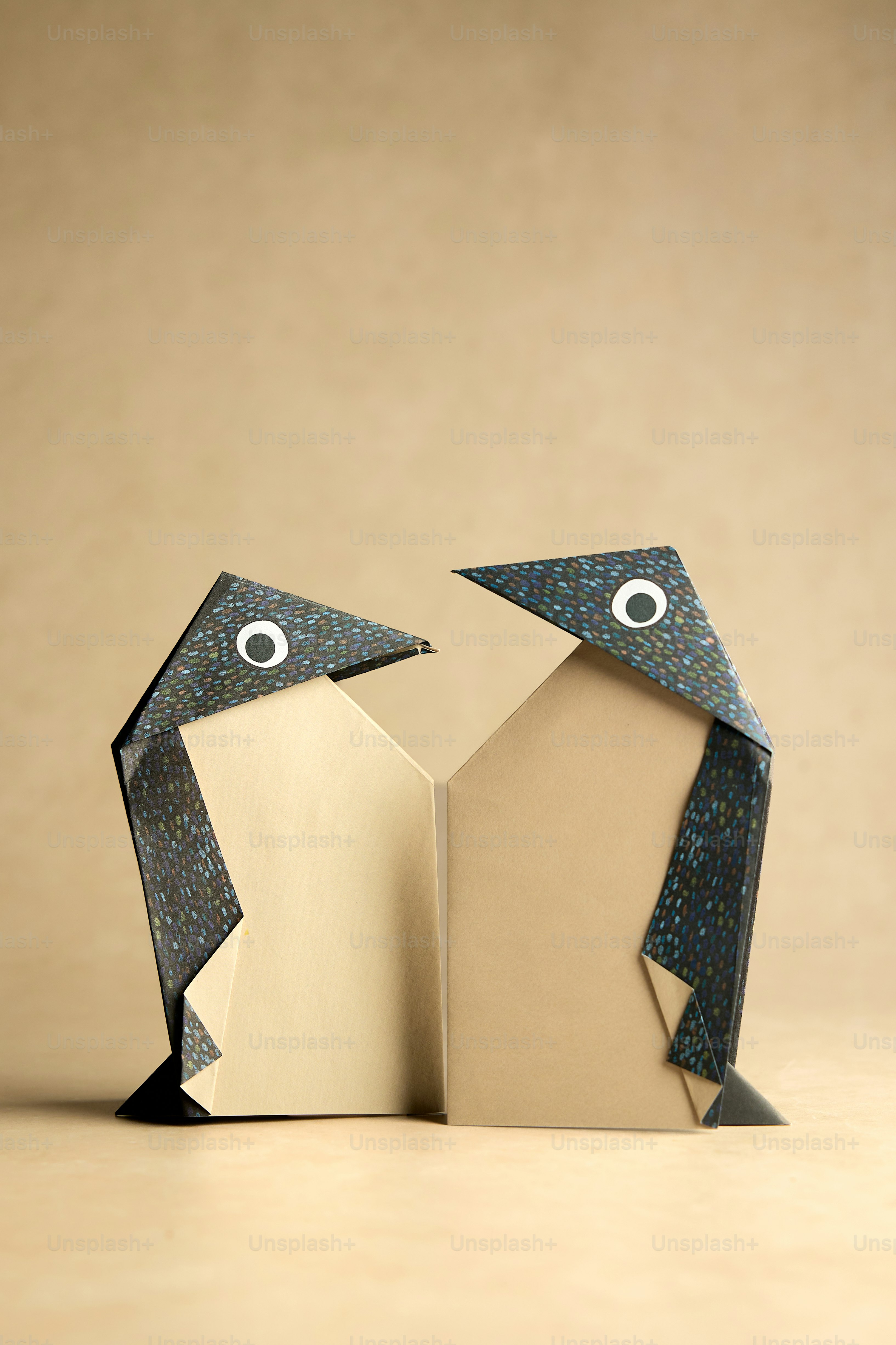 A couple of origami penguins sitting next to each other photo – Art ...