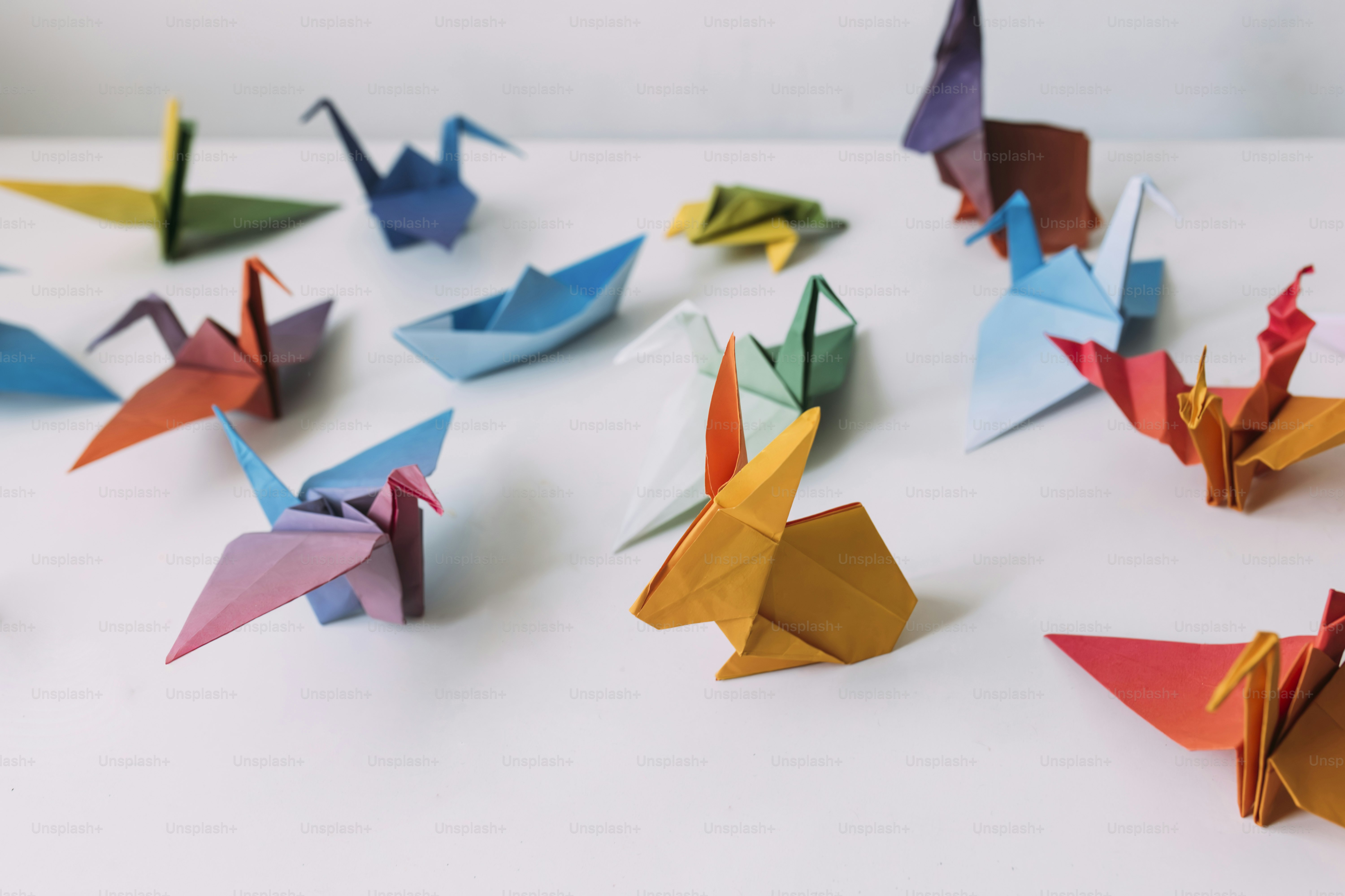 A yellow origami bird sitting on top of a bed photo – Art Image on Unsplash