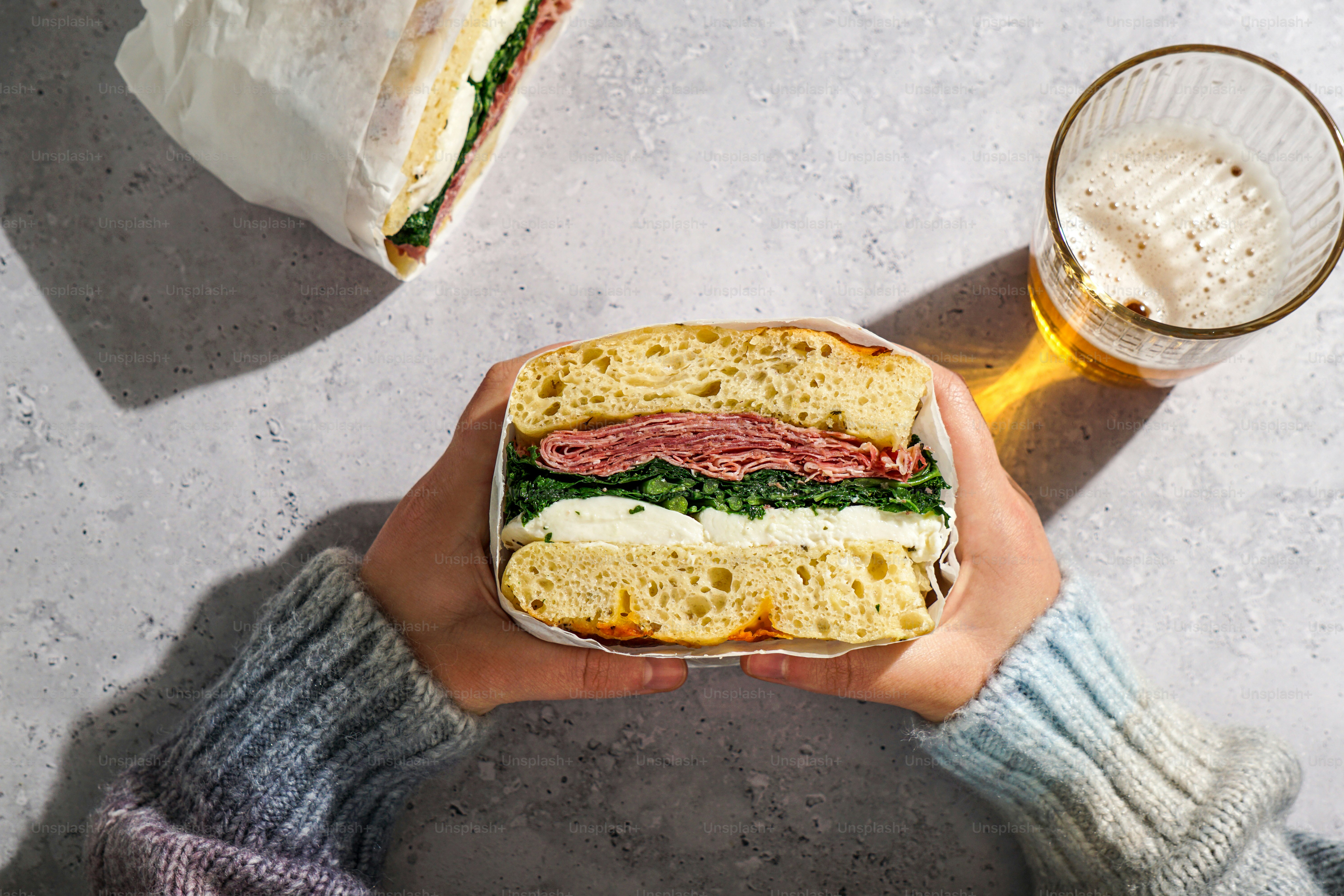 A person holding a sandwich in their hands photo – Food photography ...