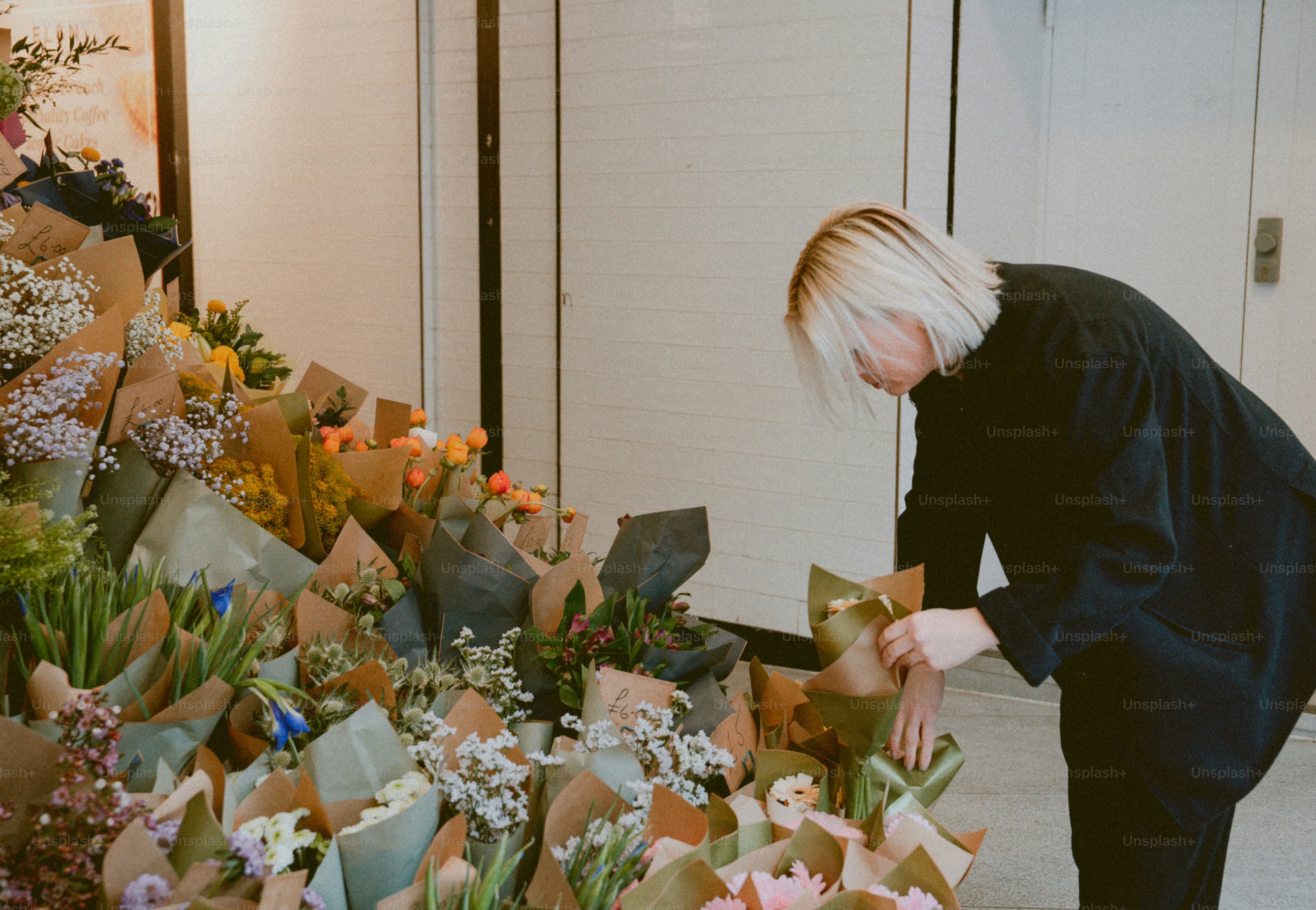 Woman arranging flowers in a shop. photo – Woman Image on Unsplash