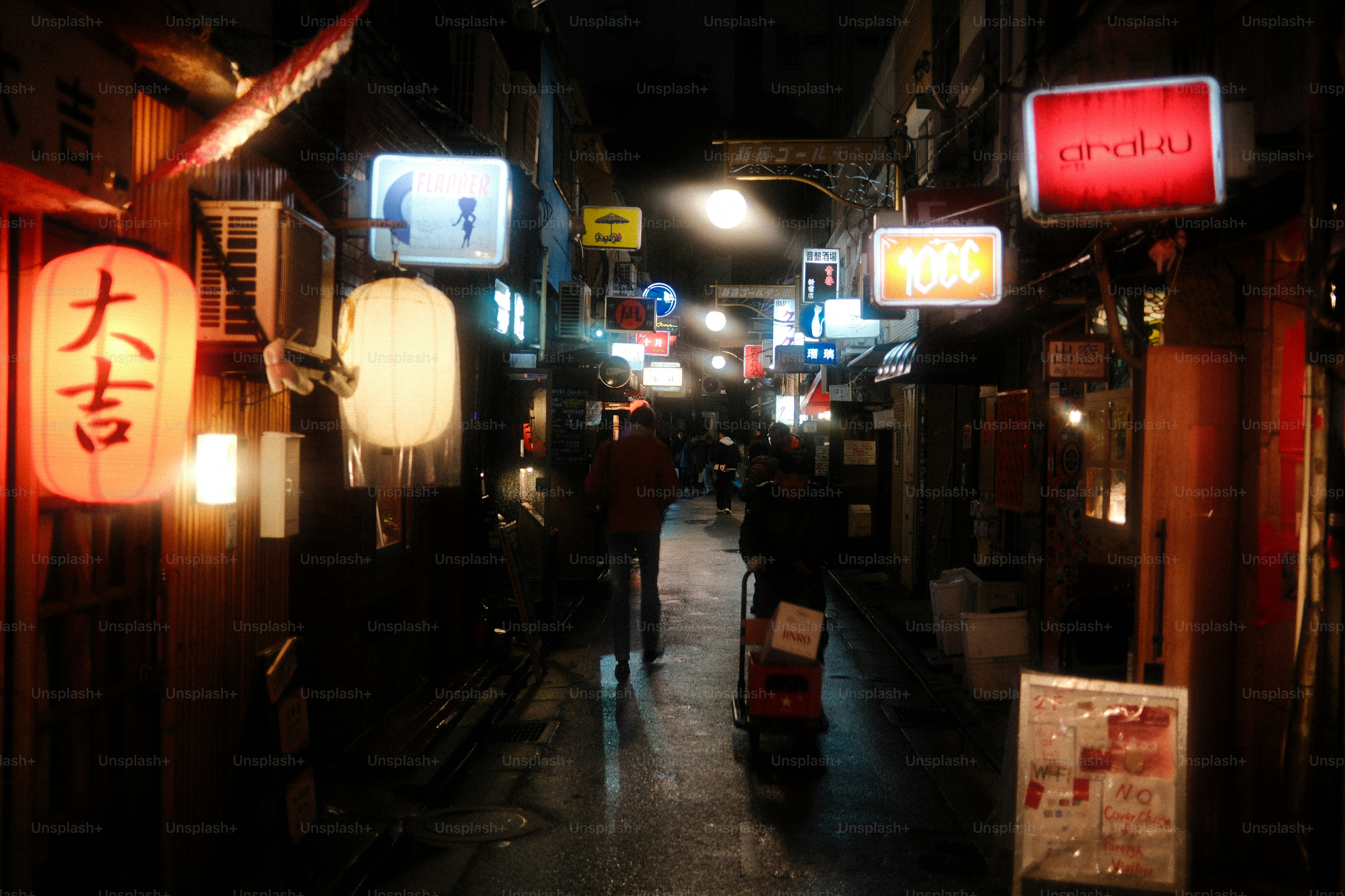 A narrow alley way with a person walking down it photo – City Image on ...