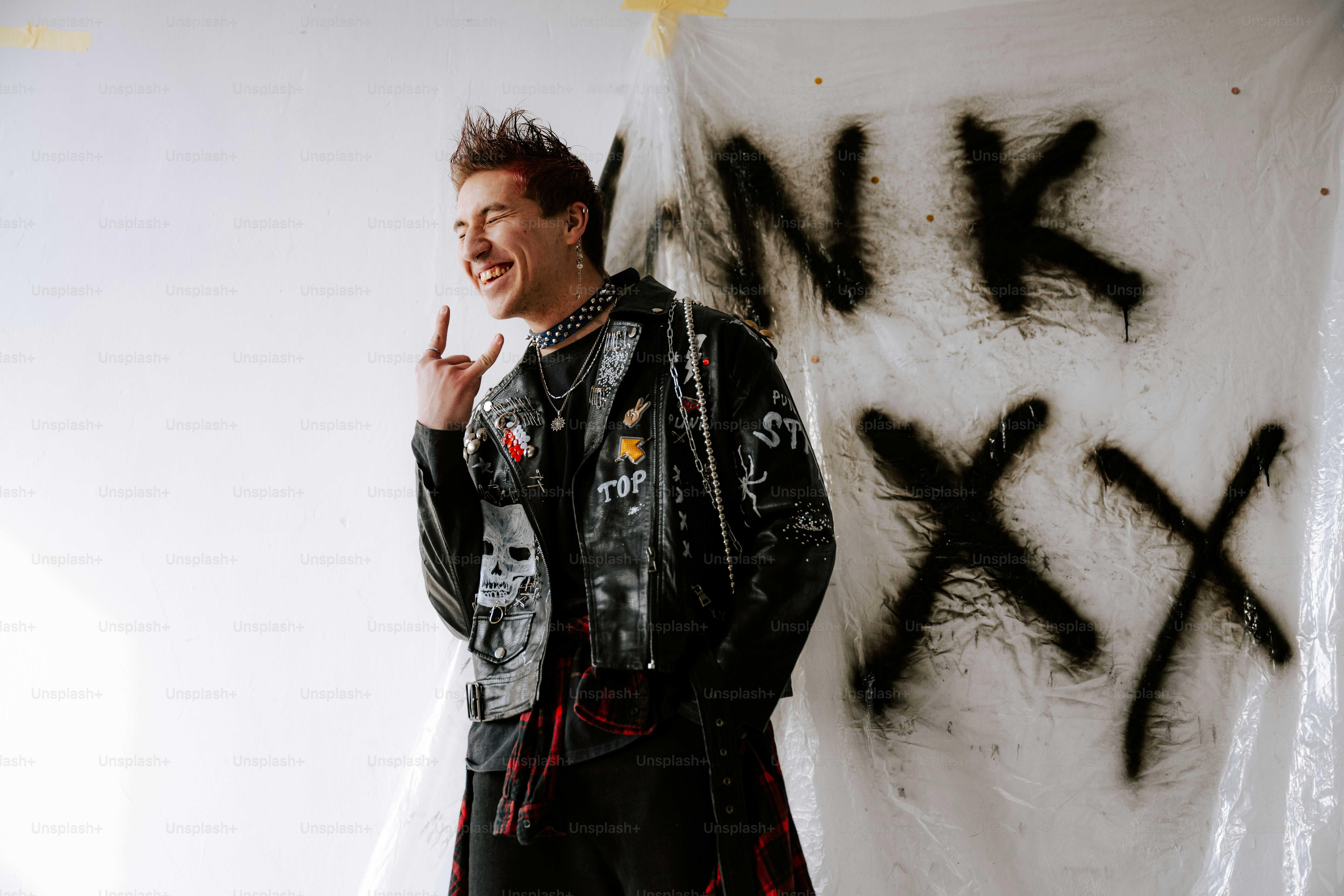 Un hombre de pie frente a una pared cubierta de grafitis foto – Imagen ...