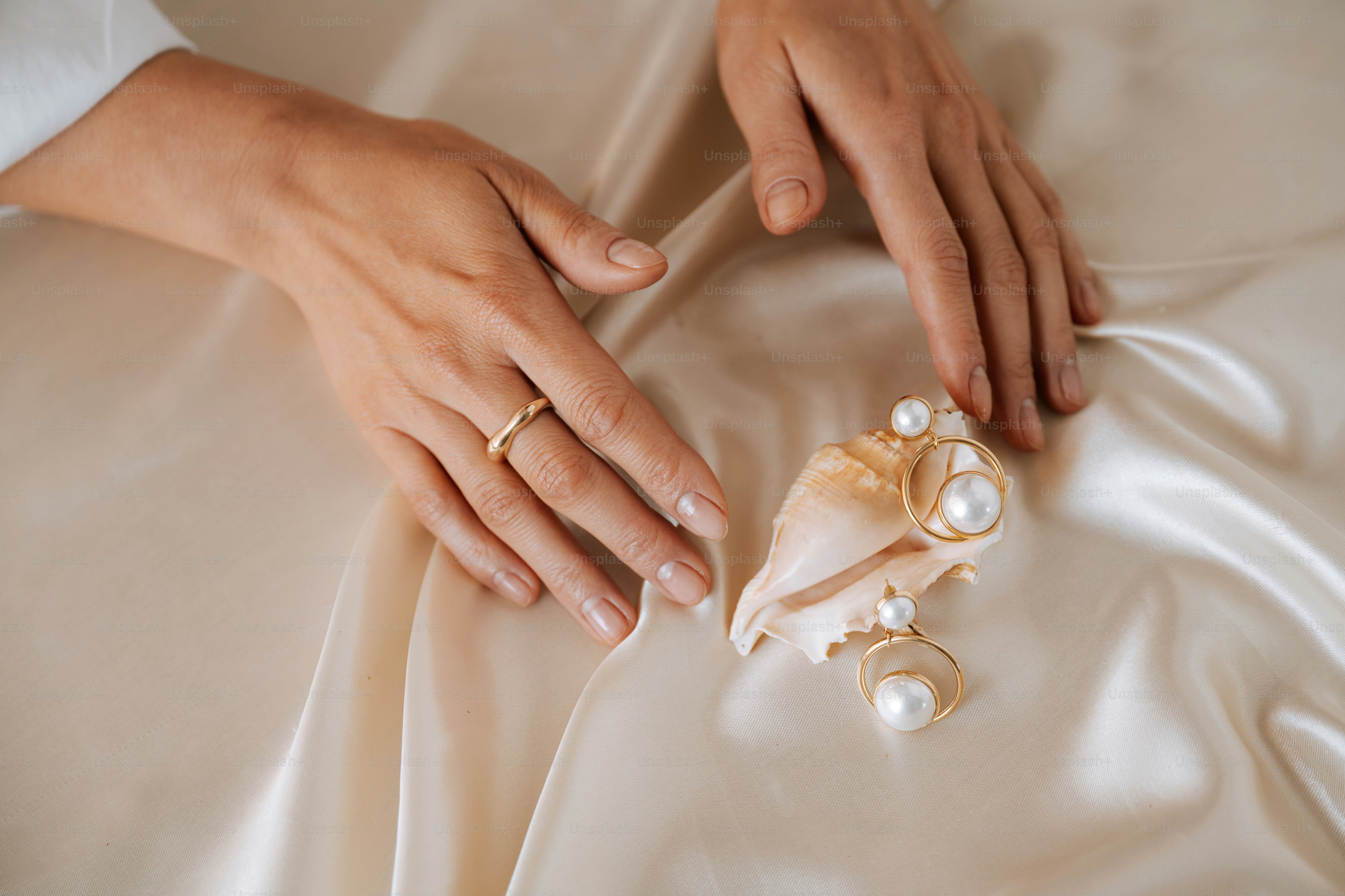 A woman's hands on a satin sheet with pearls photo – Minimal Image on Unsplash