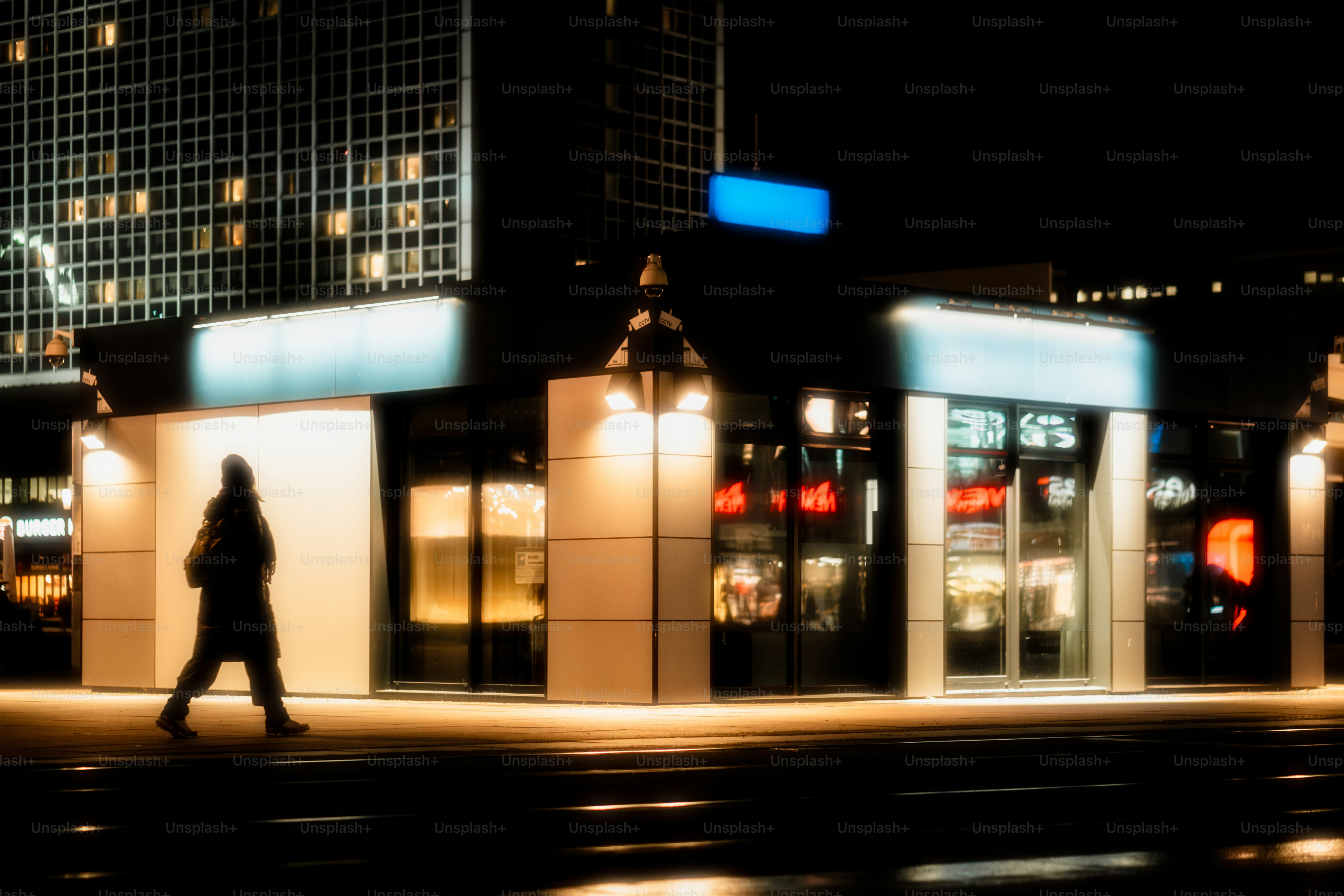 Une personne marchant dans une rue la nuit photo – Image de ...