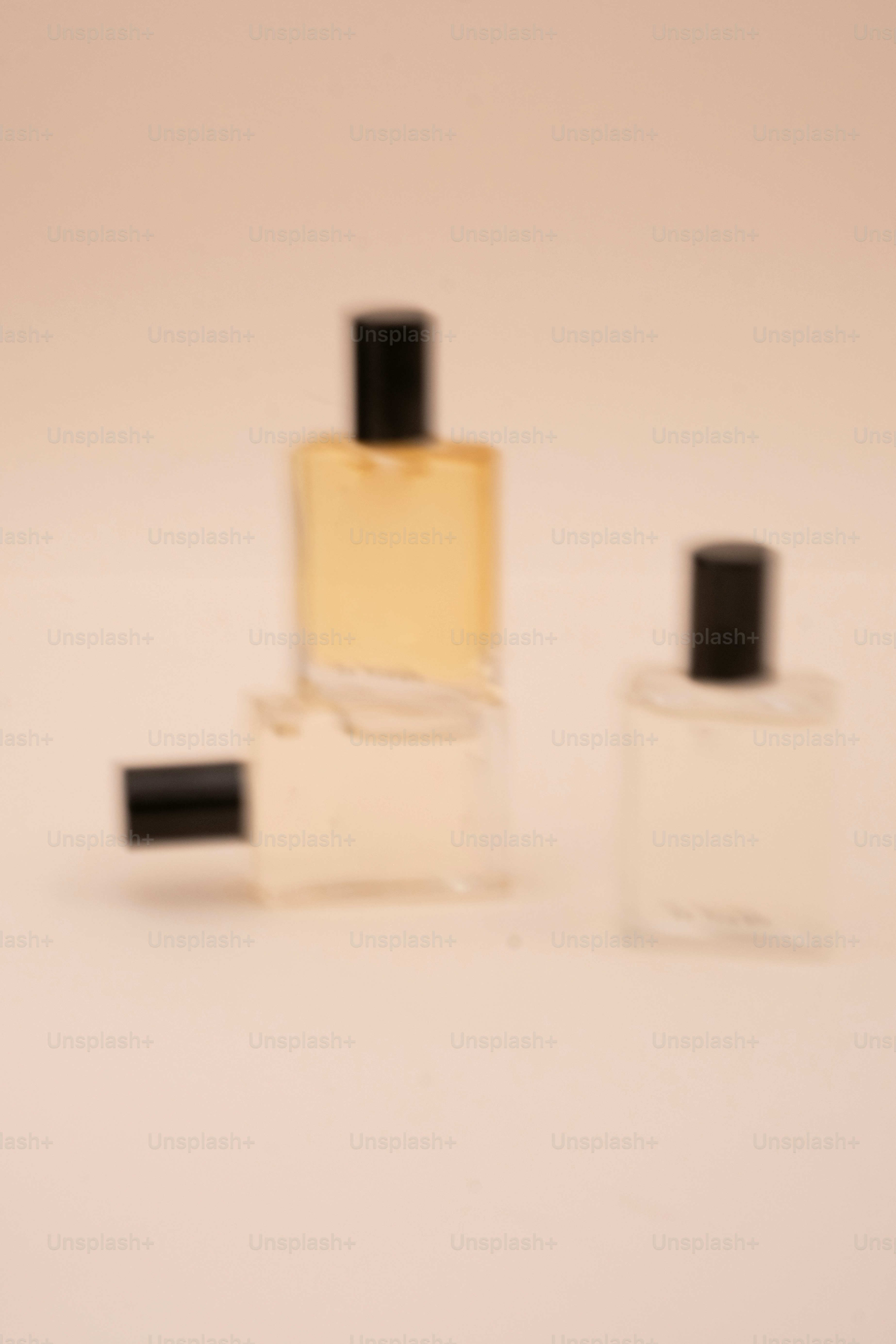 Three bottles of perfume sitting on a white surface photo – Perfume ...