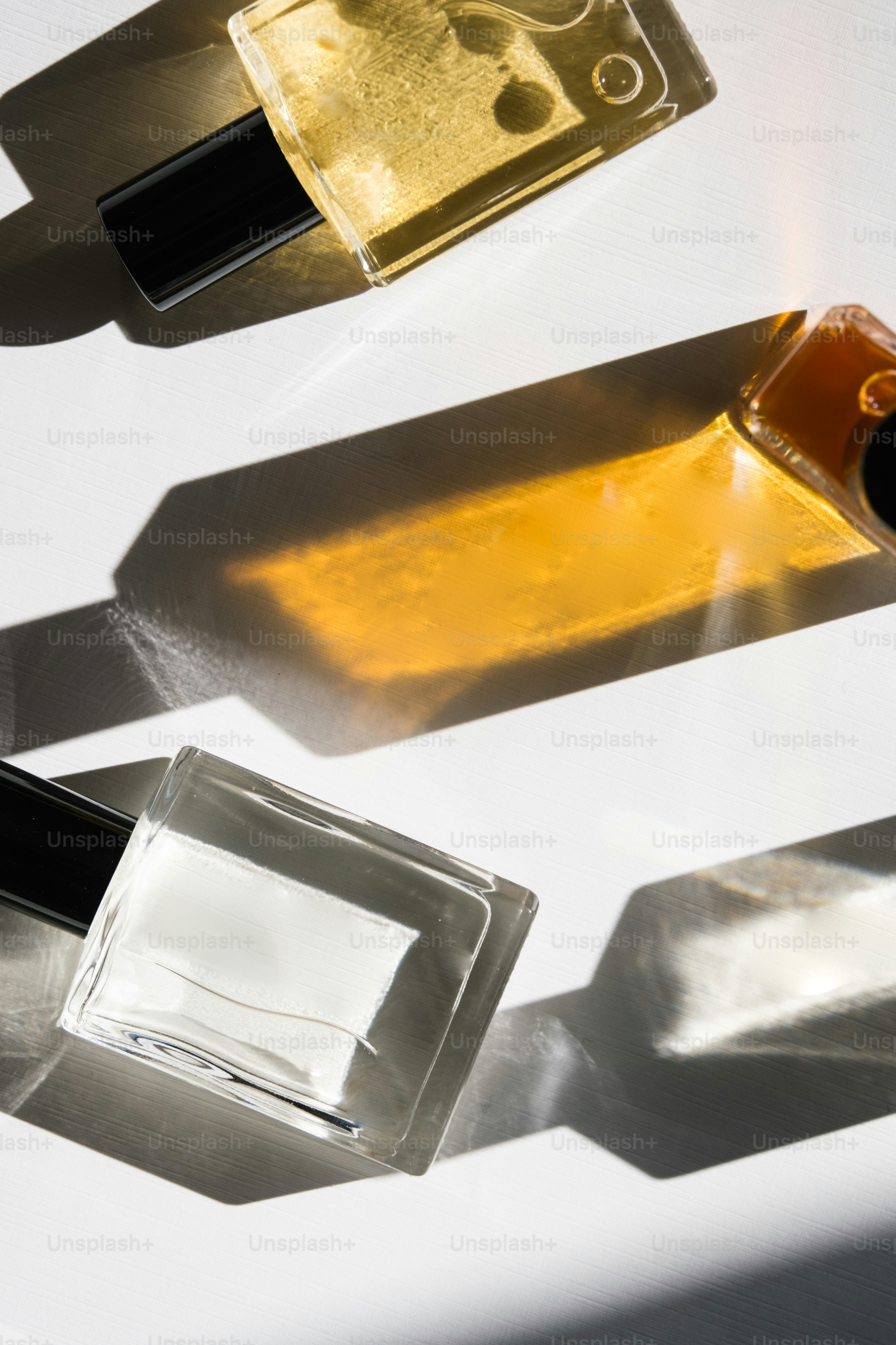 Three bottles of perfume sitting next to each other photo – Glass ...