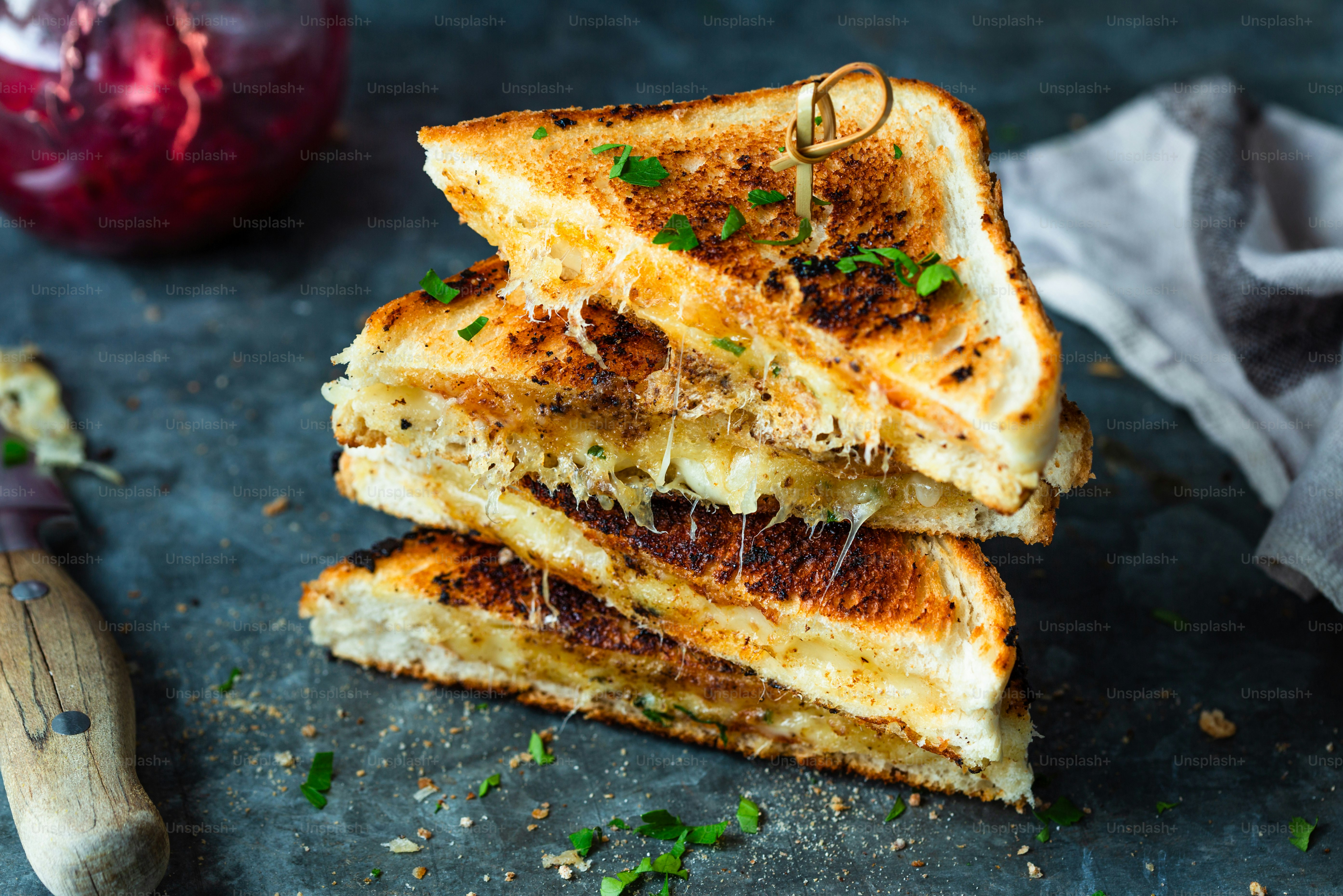 A stack of grilled cheese sandwiches sitting on top of a table photo ...