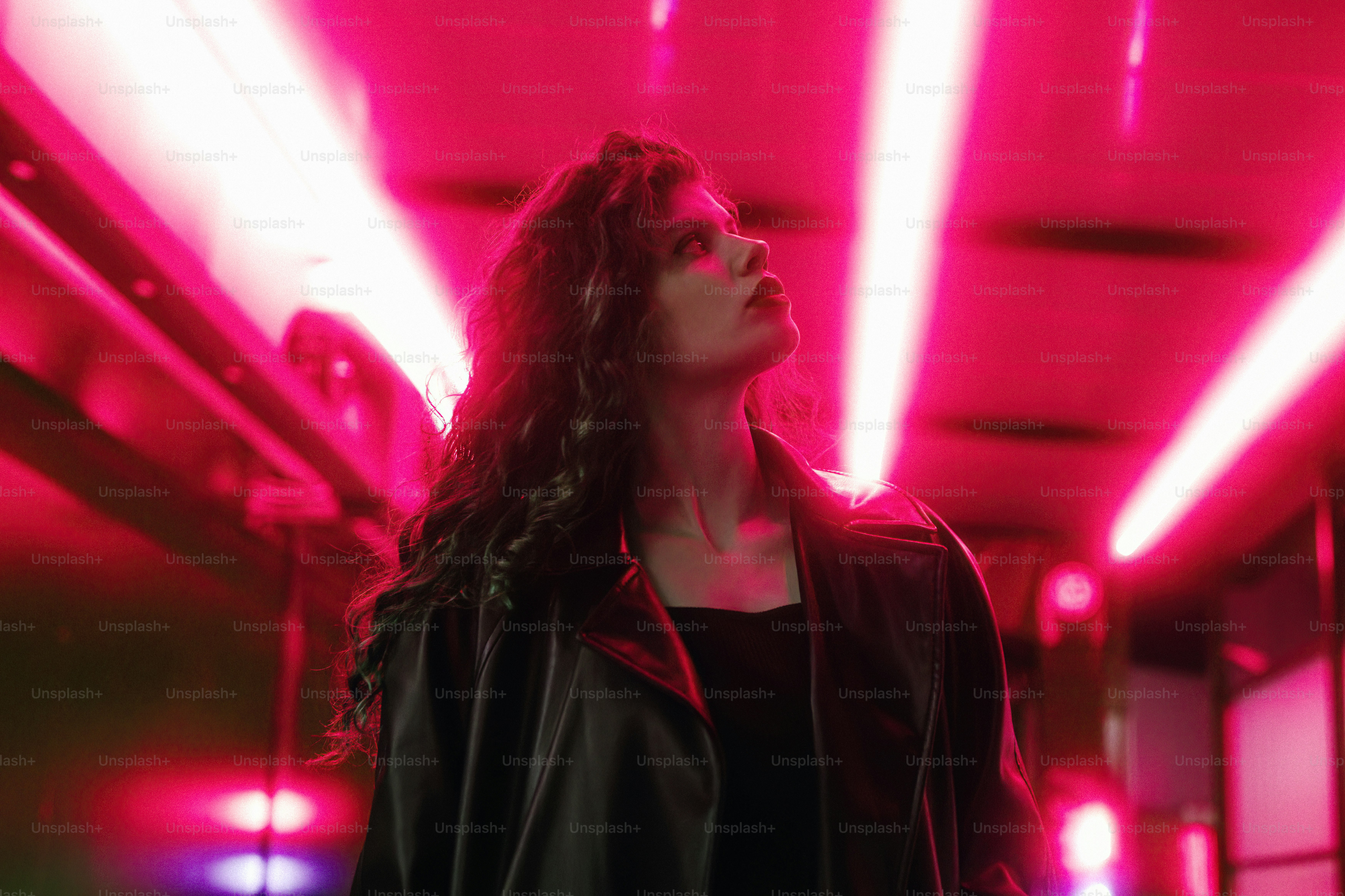 A woman standing in a room with red lights photo – Atmosphere Image on ...