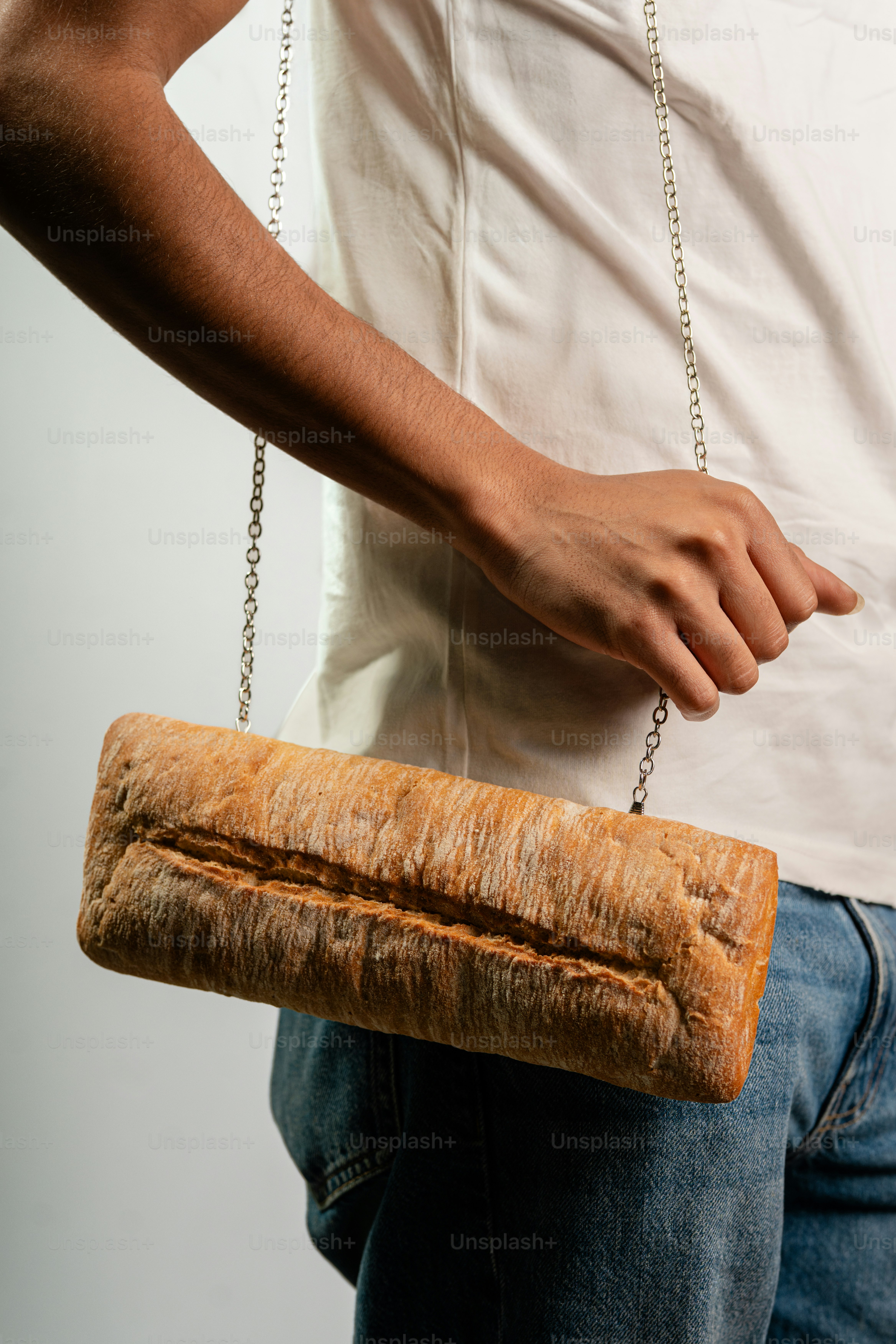 A man is holding a long loaf of bread photo – Playing Image on Unsplash