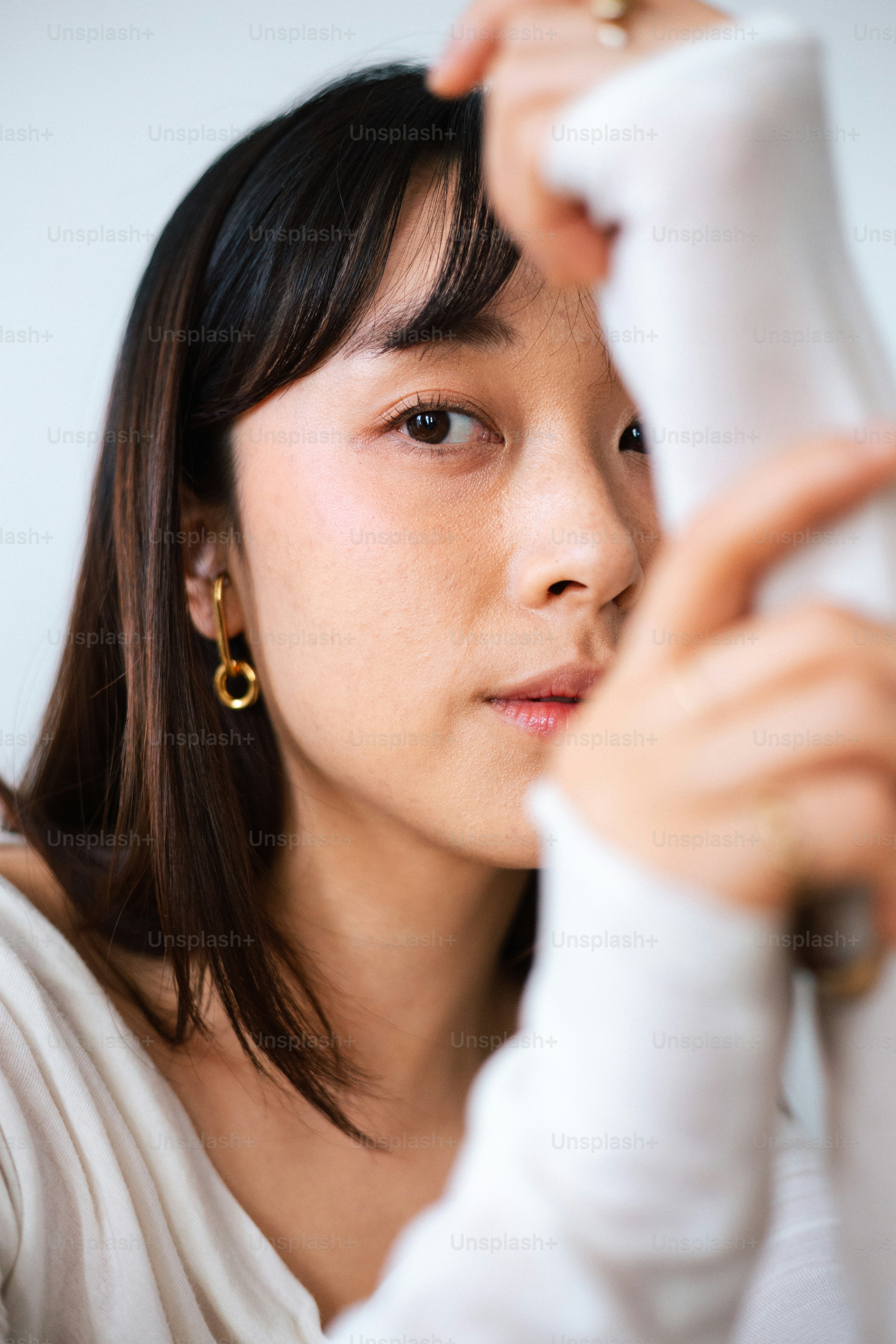 A woman holding a white object up to her face photo – Woman Image on ...