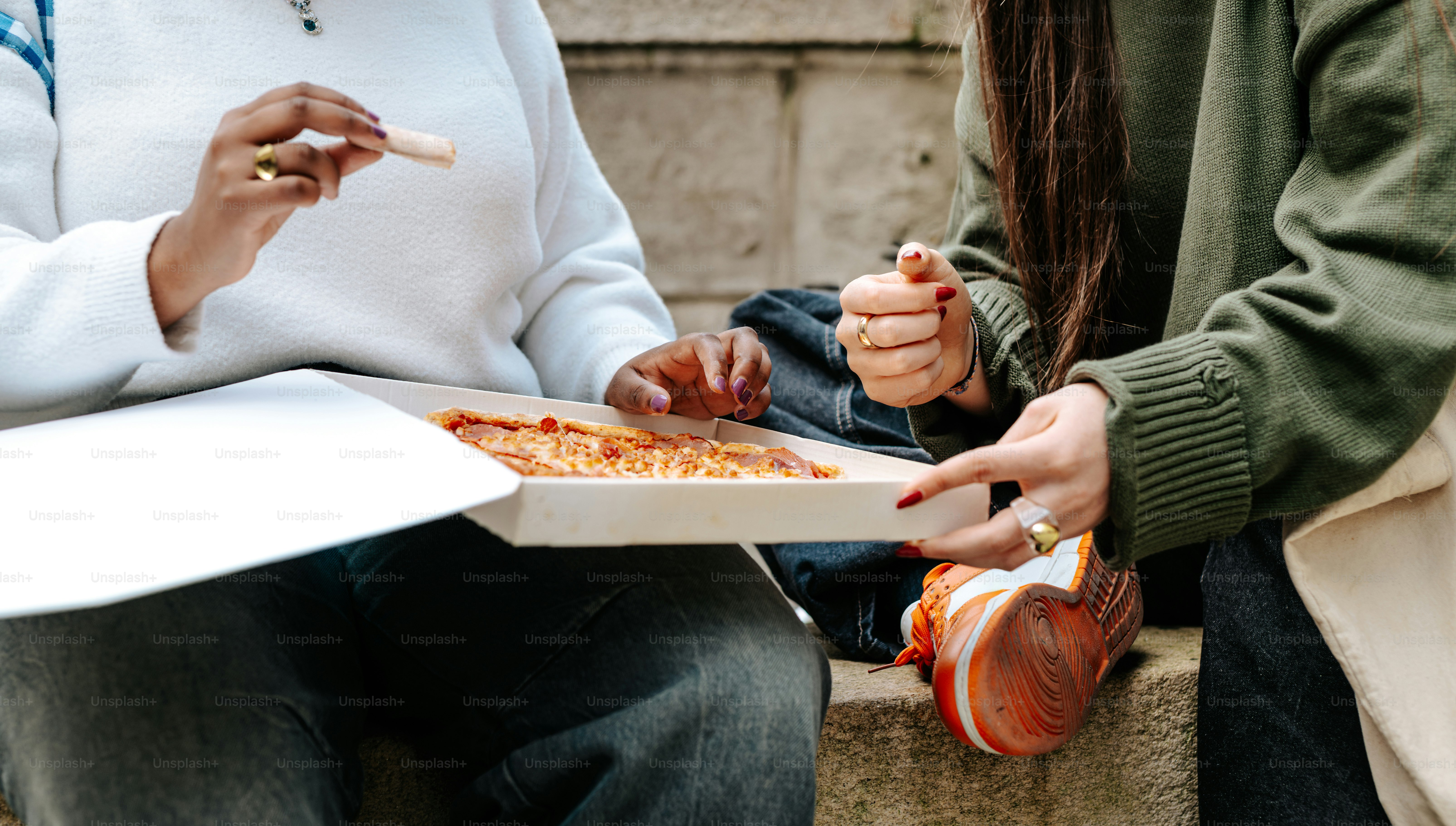 A group of people sitting down eating pizza photo – Food experience ...