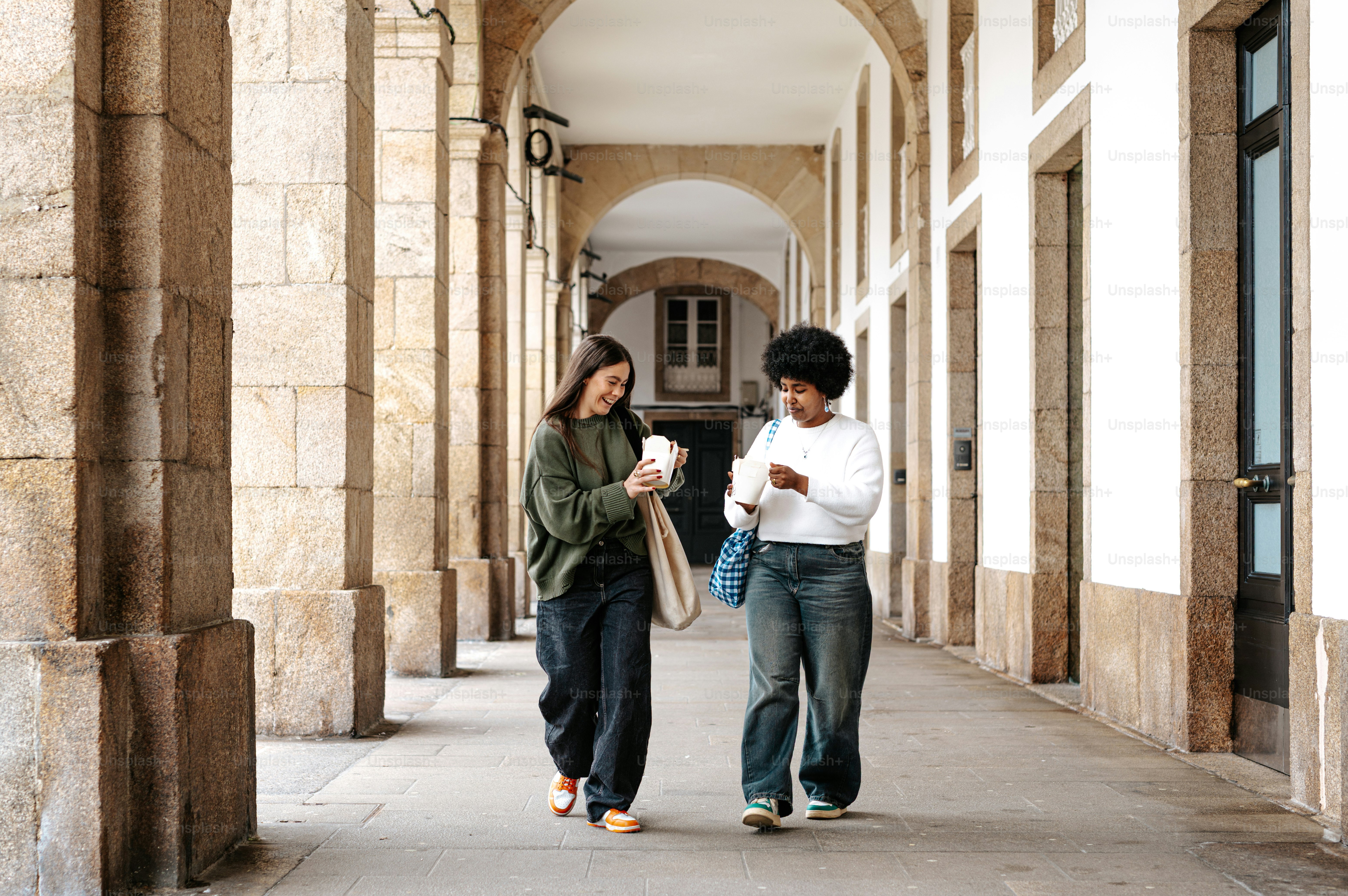 Dos mujeres caminando por un pasillo entre dos edificios foto – Imagen de Víveres en Unsplash