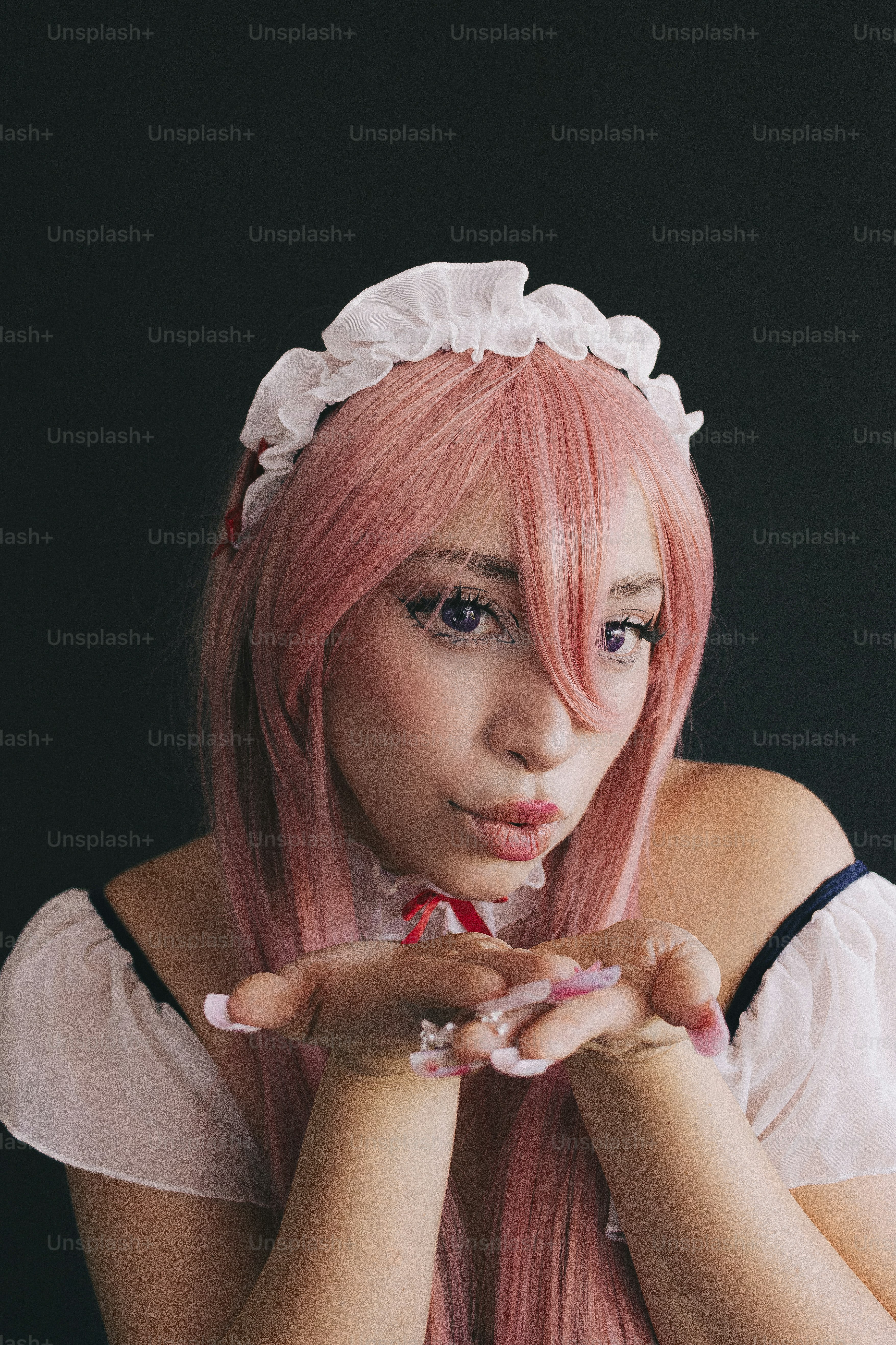 Una cosplayer con el pelo rosa lanza un beso. foto – Imagen de ...