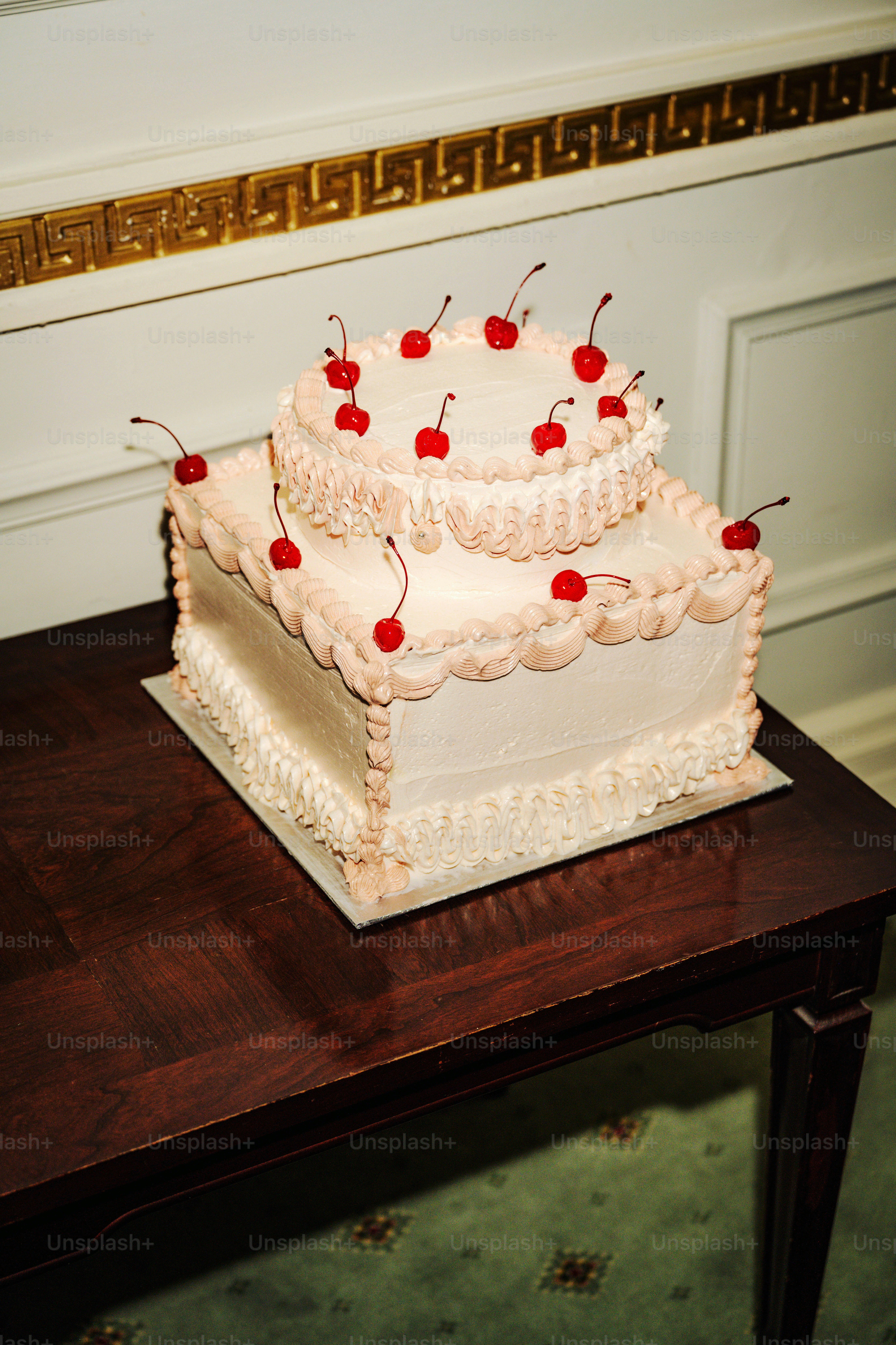 A two-tiered cake adorned with cherries. photo – Cake Image on Unsplash