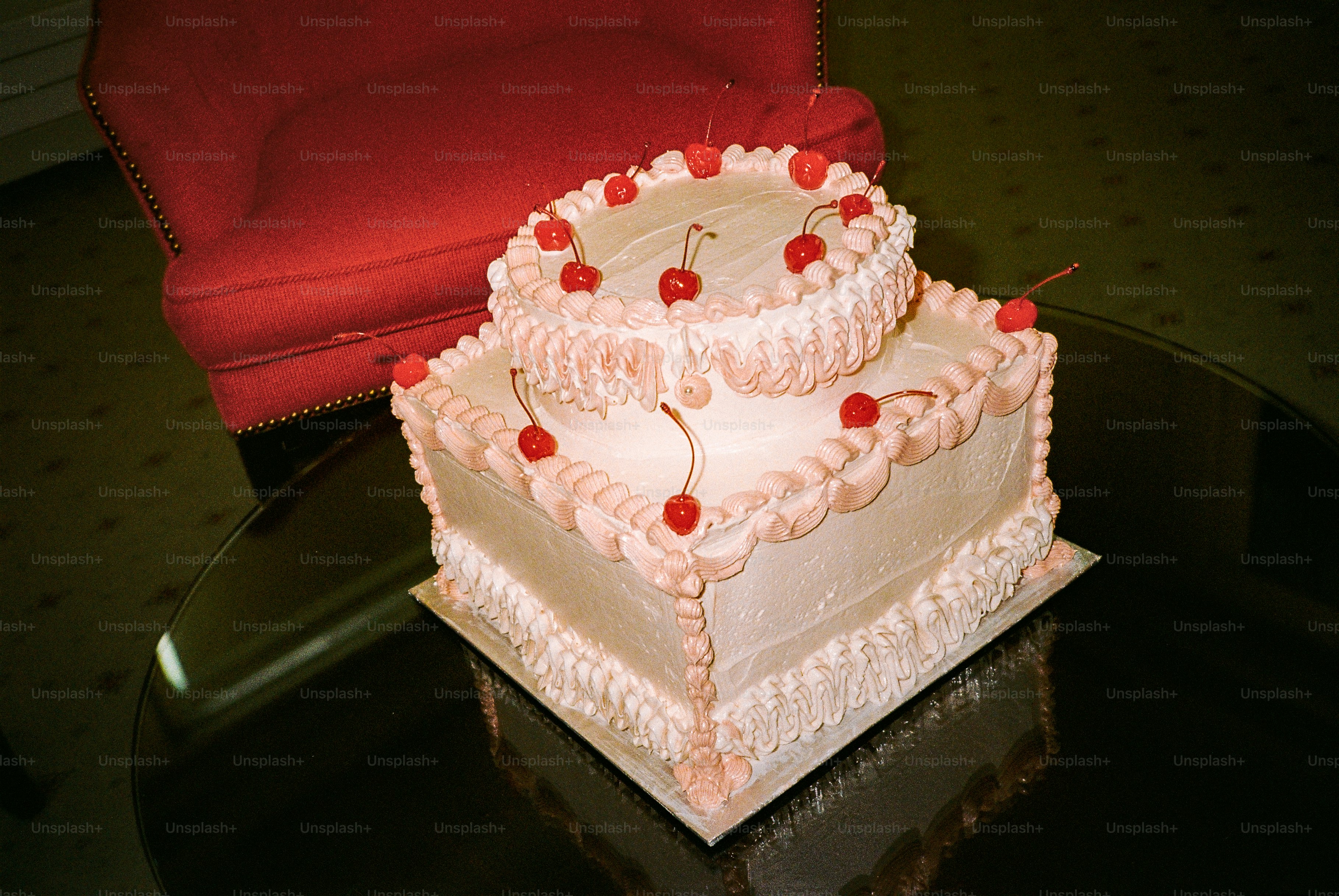 A two-tiered cake decorated with cherries. photo – Cake Image on Unsplash