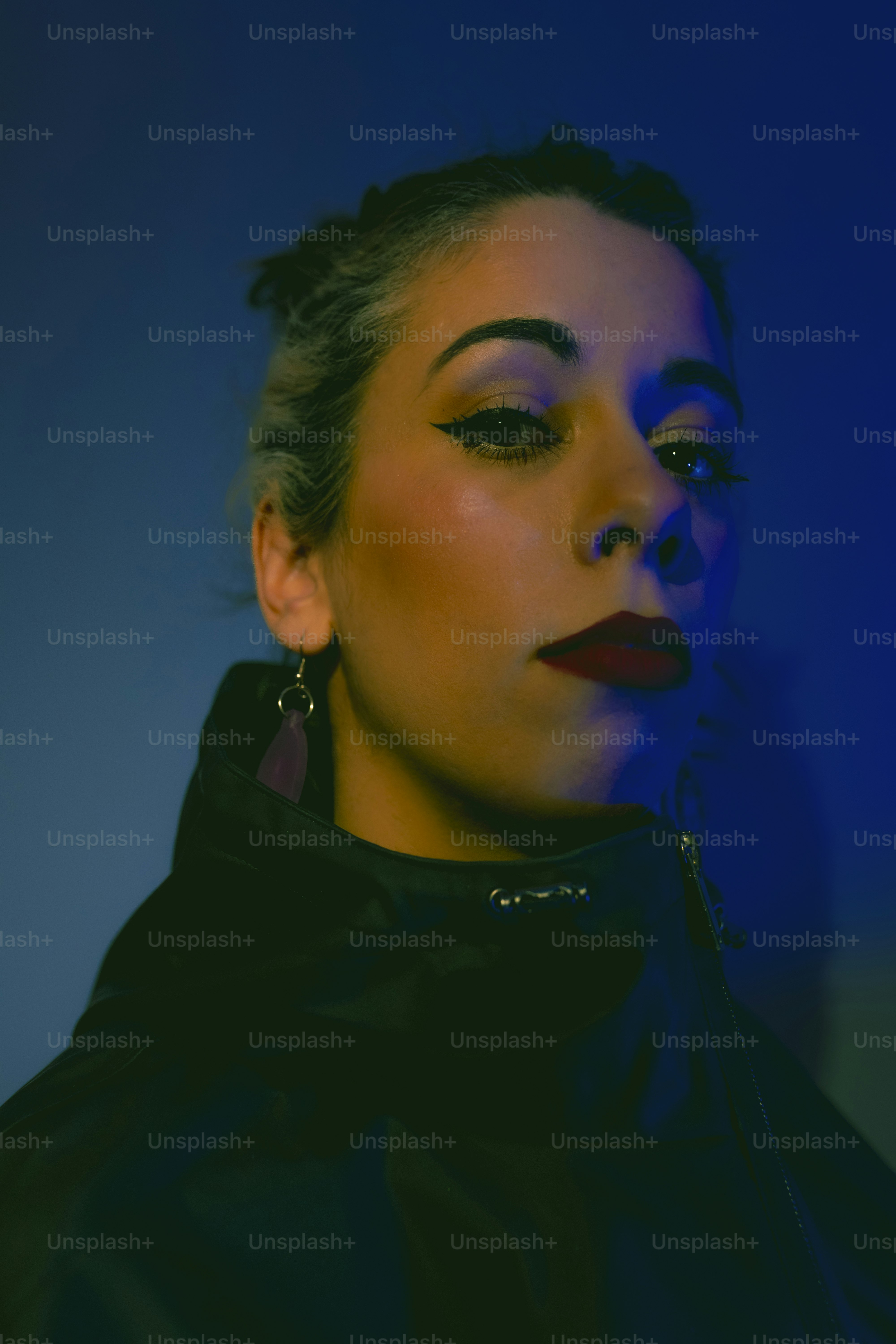 La mujer posa con maquillaje e iluminación dramáticos. foto – Imagen de ...